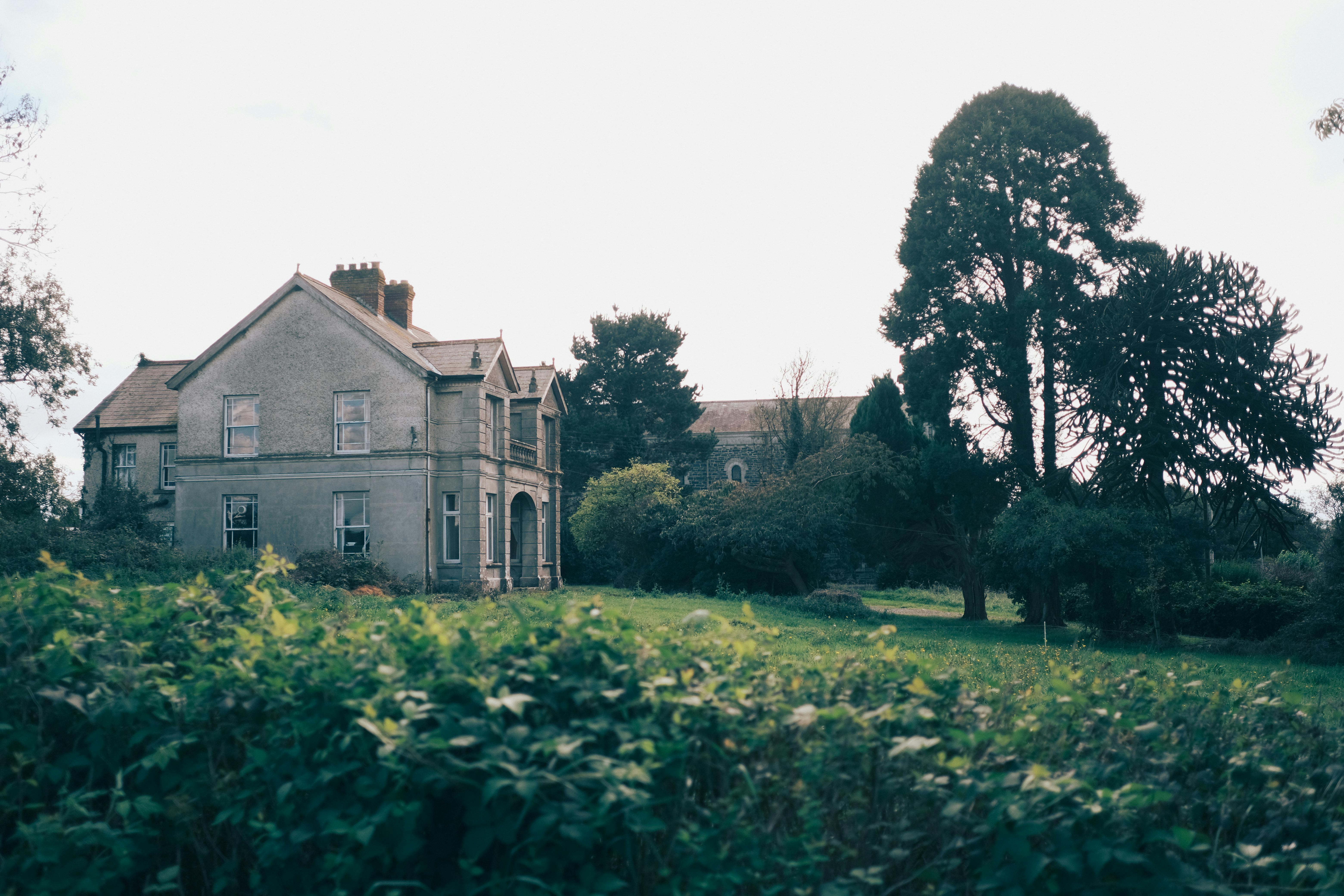 Bush and Trees around Vintage Mansion Building · Free Stock Photo