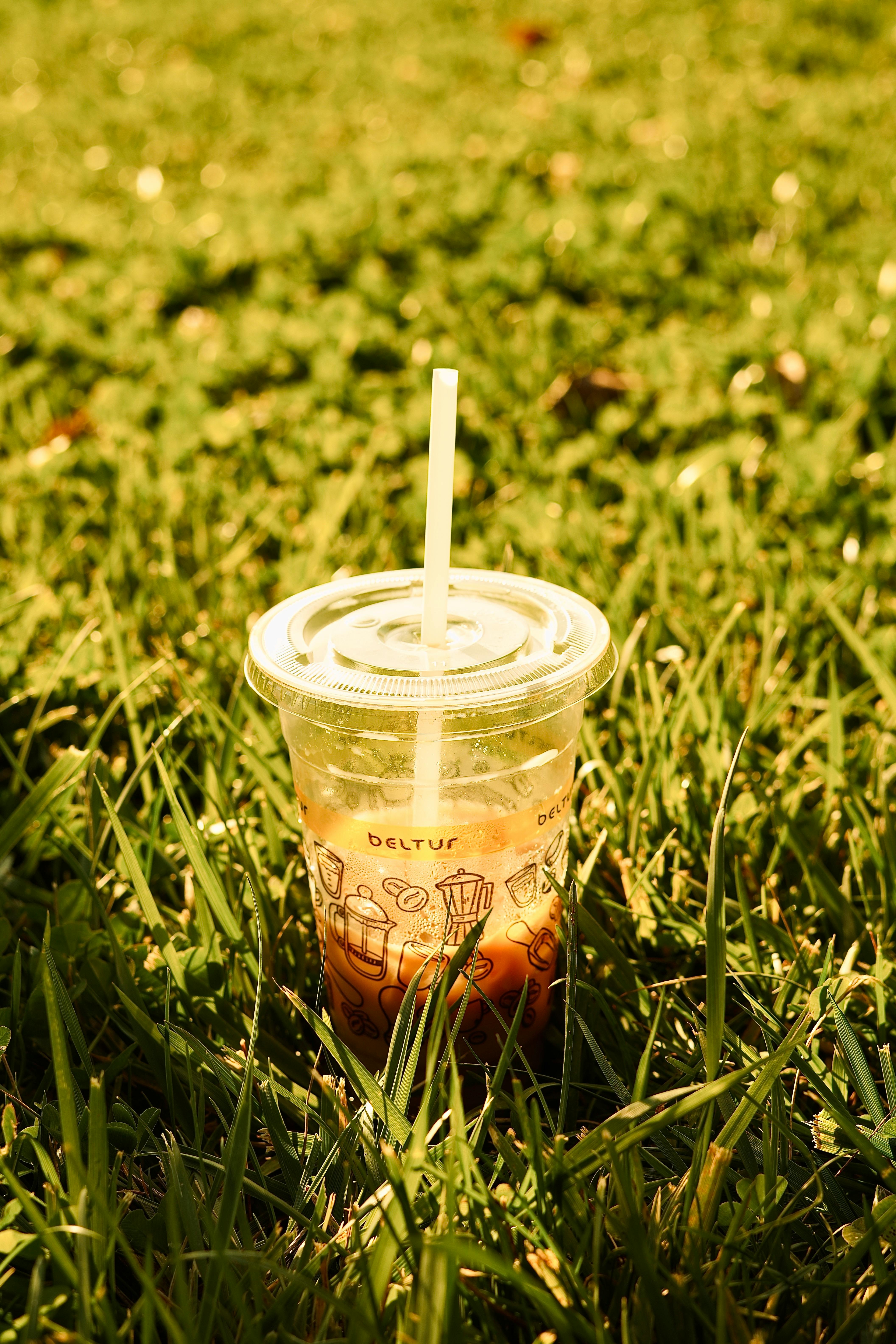 A Drink in a Plastic Cup with a Straw Standing on the Ground · Free ...