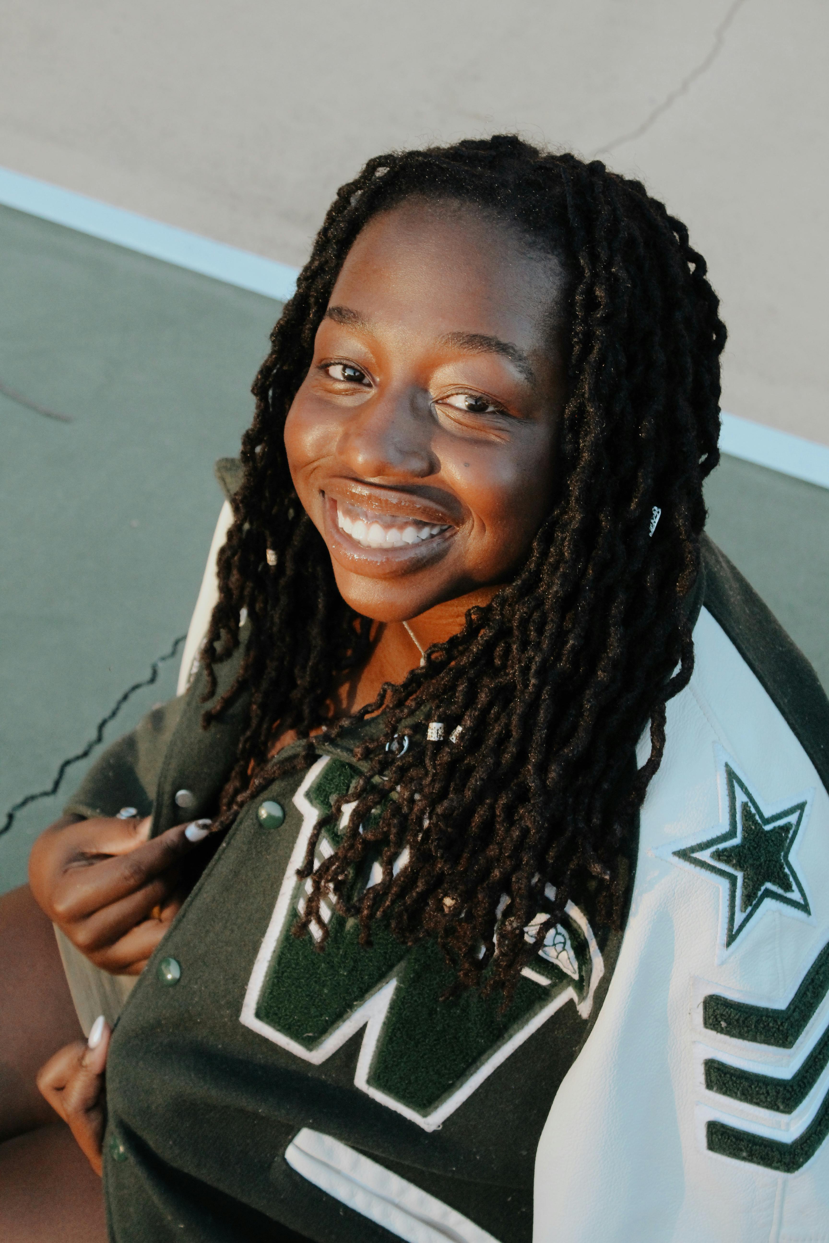 Smiling Woman in Varsity Jacket · Free Stock Photo