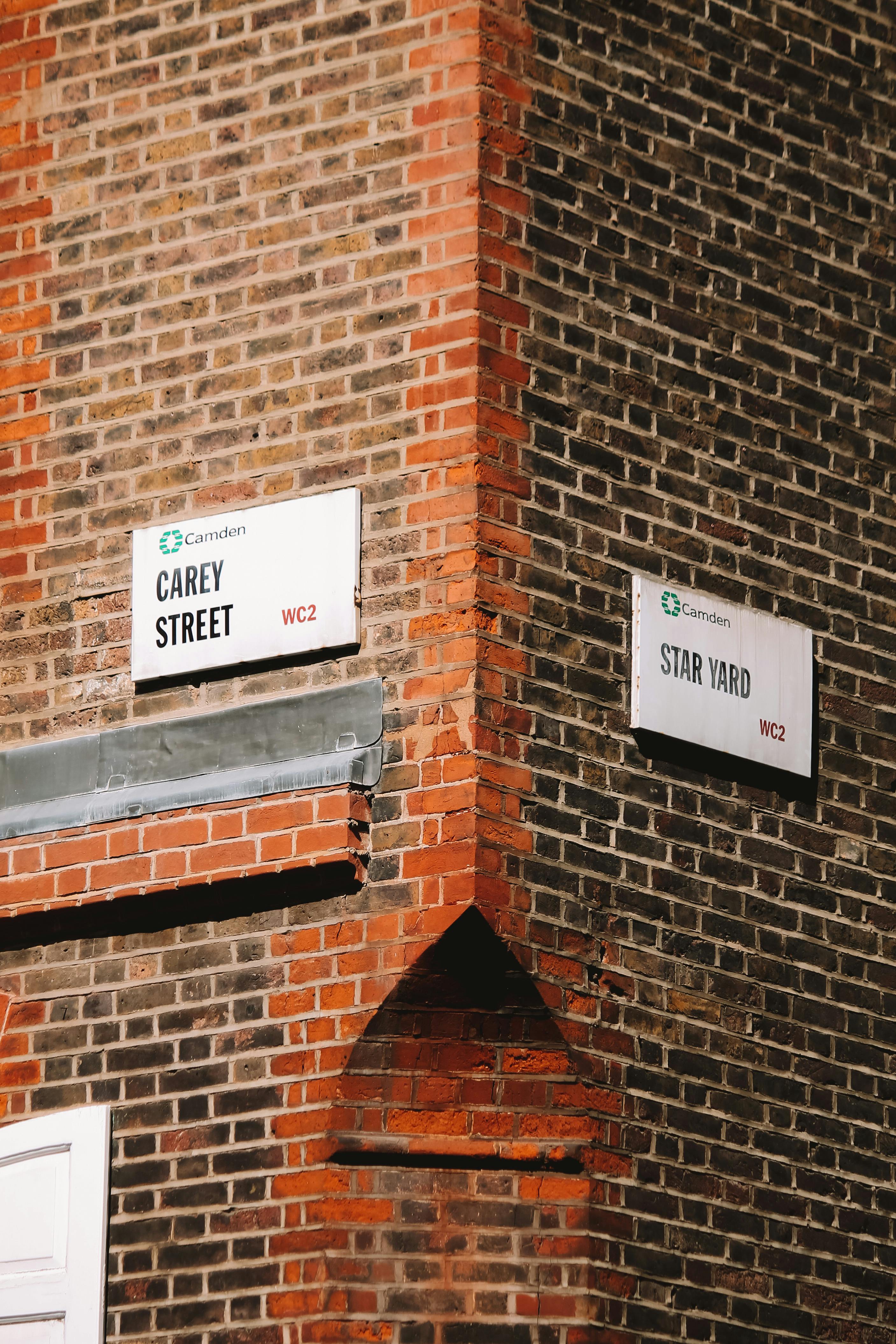 Corner of a Brick House with Street Name Signs · Free Stock Photo