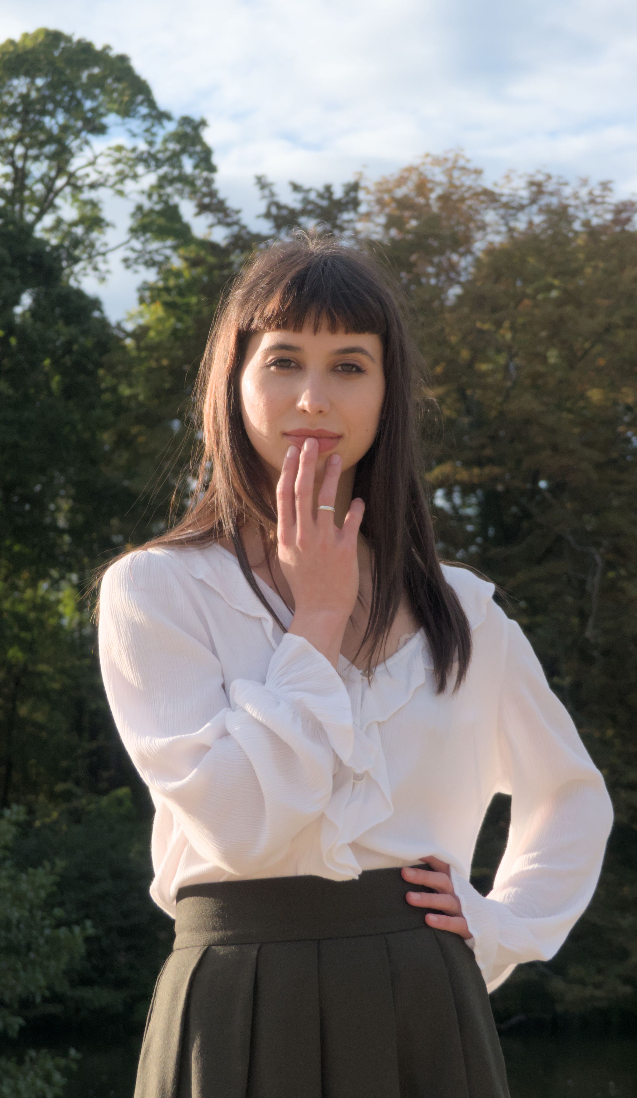 Model in White Ruffled V-Neck Blouse in the Park · Free Stock Photo