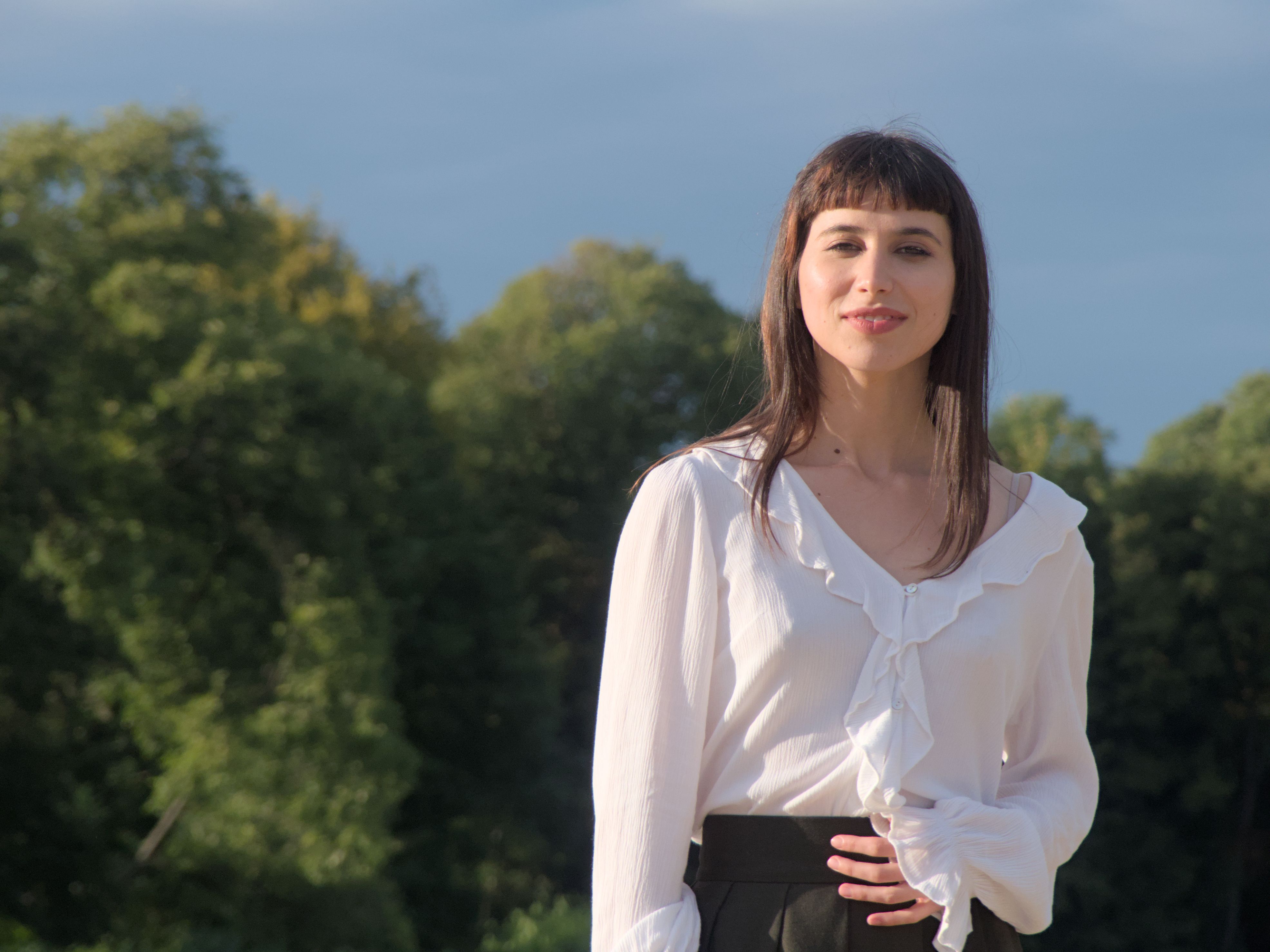 Model in White Ruffled V-Neck Silk Blouse in the Park · Free Stock Photo