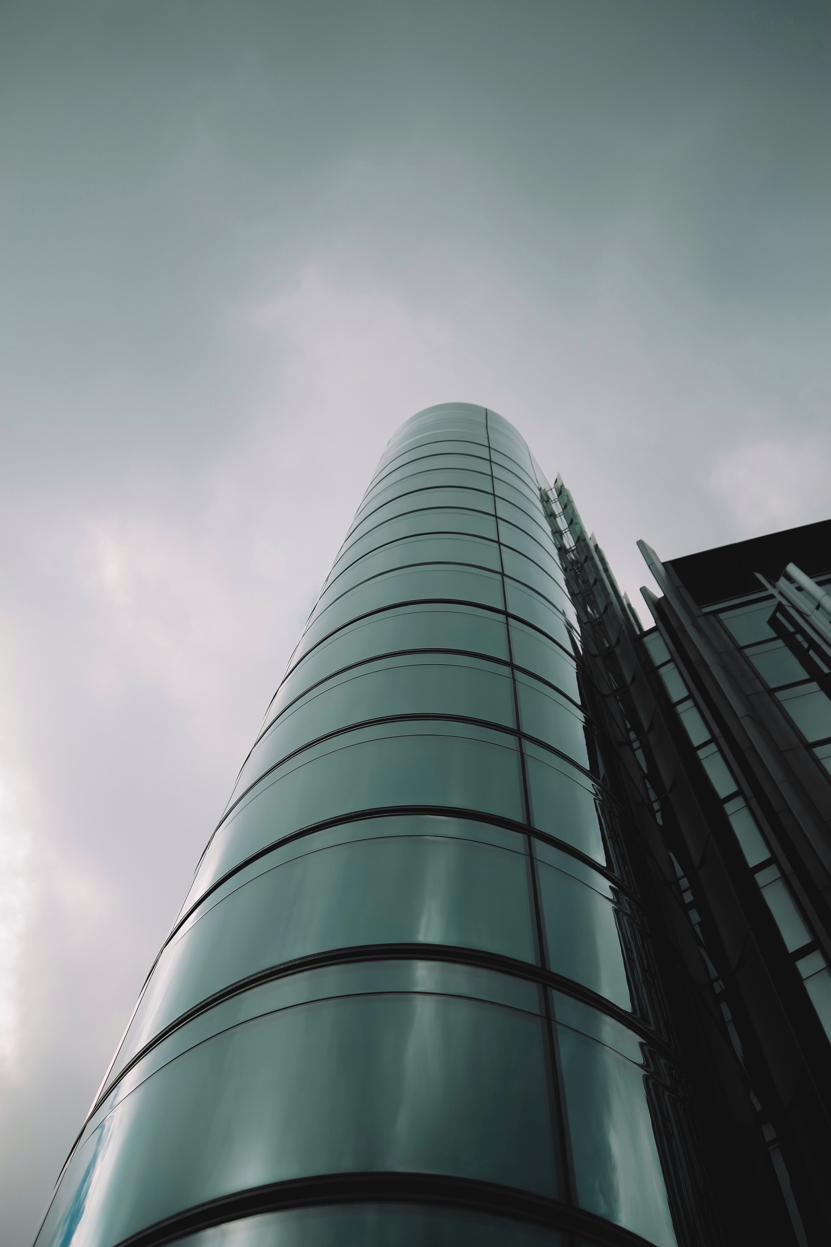 Glass Tower of a Modern Building Against the Cloudy Sky · Free Stock Photo