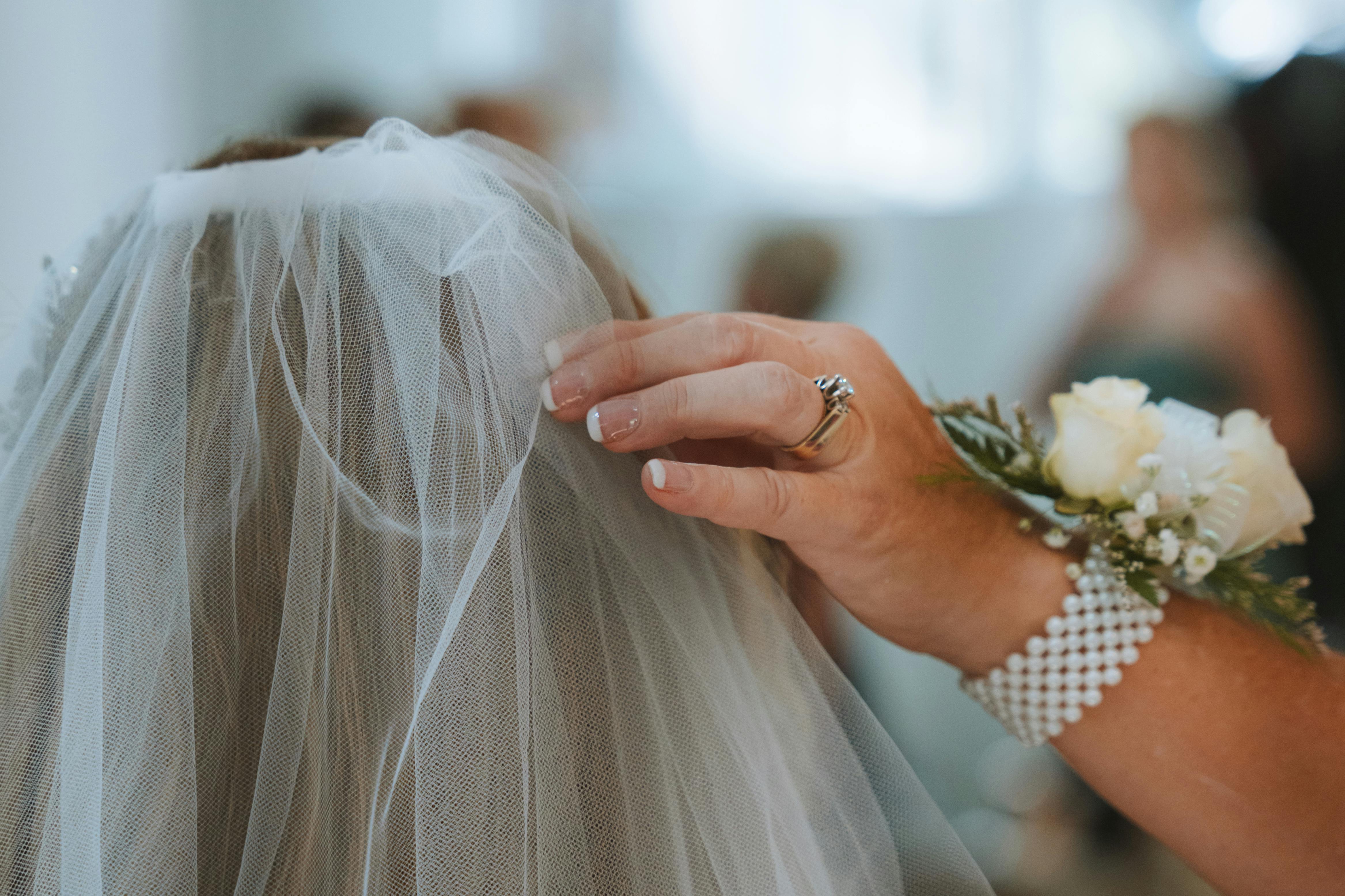 Close-up of a Hand with Flowers Touching the Brides Veil · Free Stock Photo
