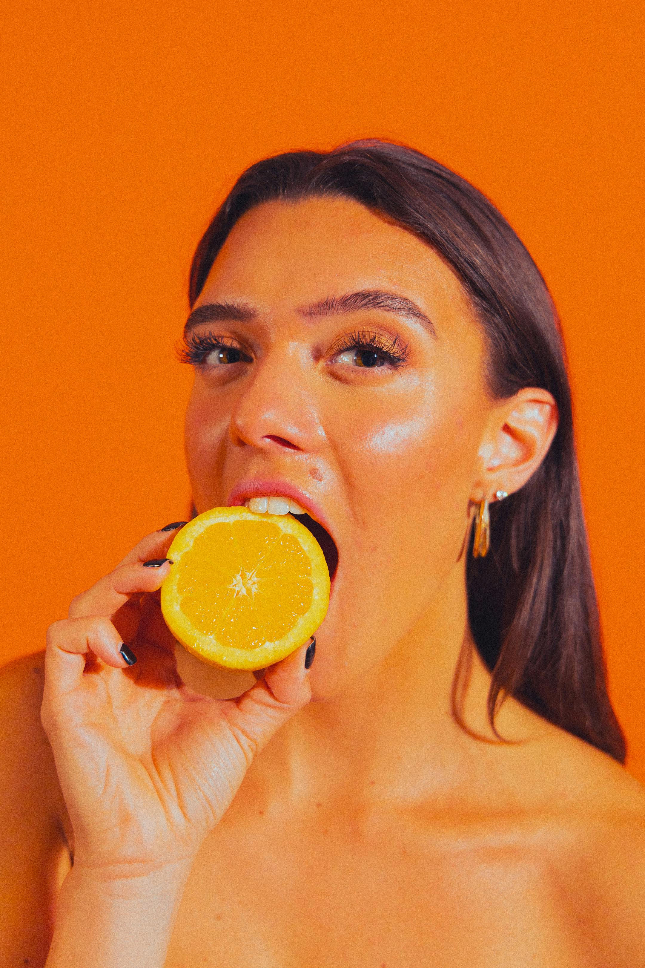 Portrait of Woman Eating Orange · Free Stock Photo
