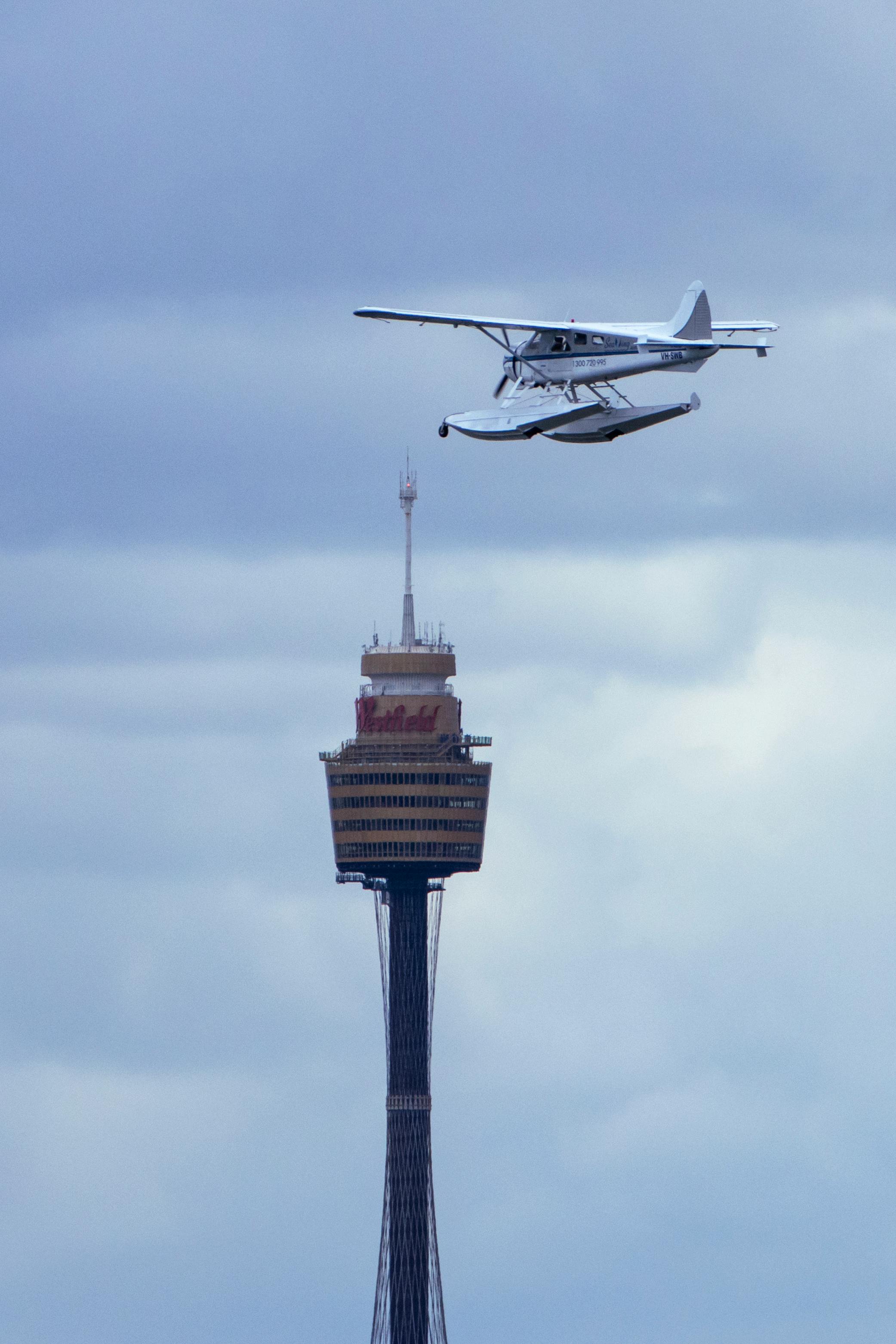 Hydroplane Flying over Broadcast Tower · Free Stock Photo