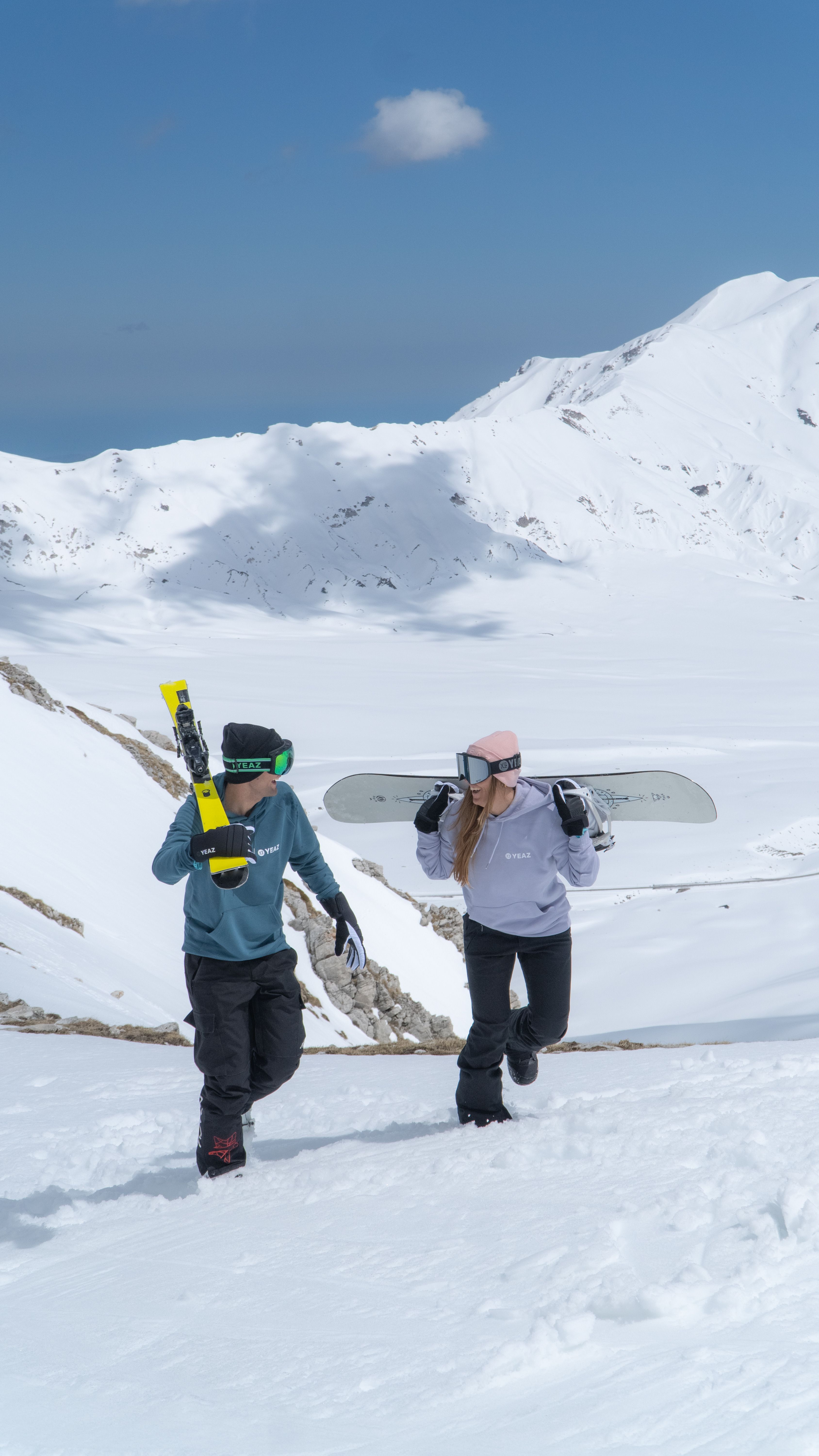 Couple with Skis and Snowboard Climbing the Ski Slope · Free Stock Photo