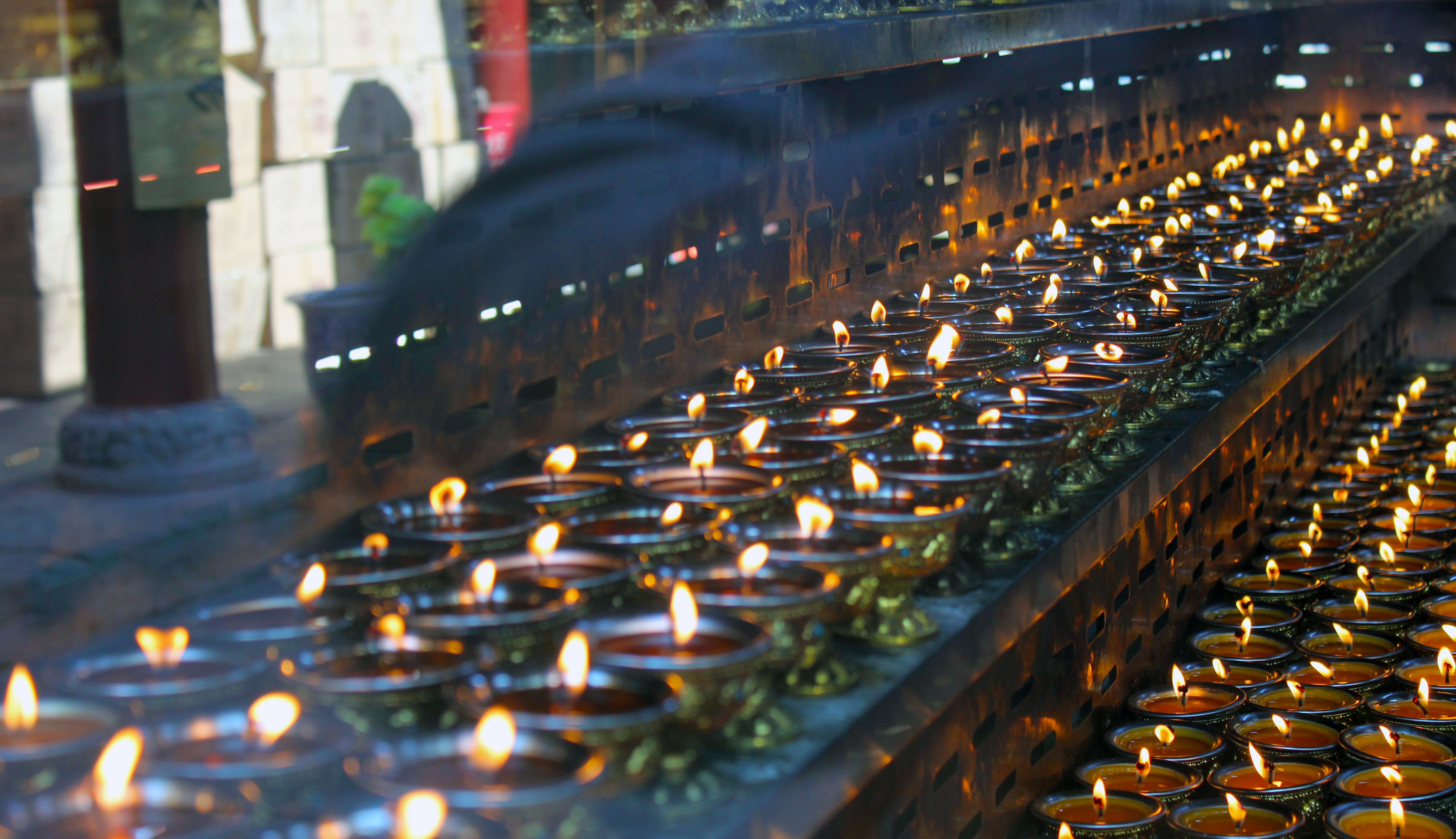 Rows of Illuminated Oil Lamps in Temple Setting · Free Stock Photo