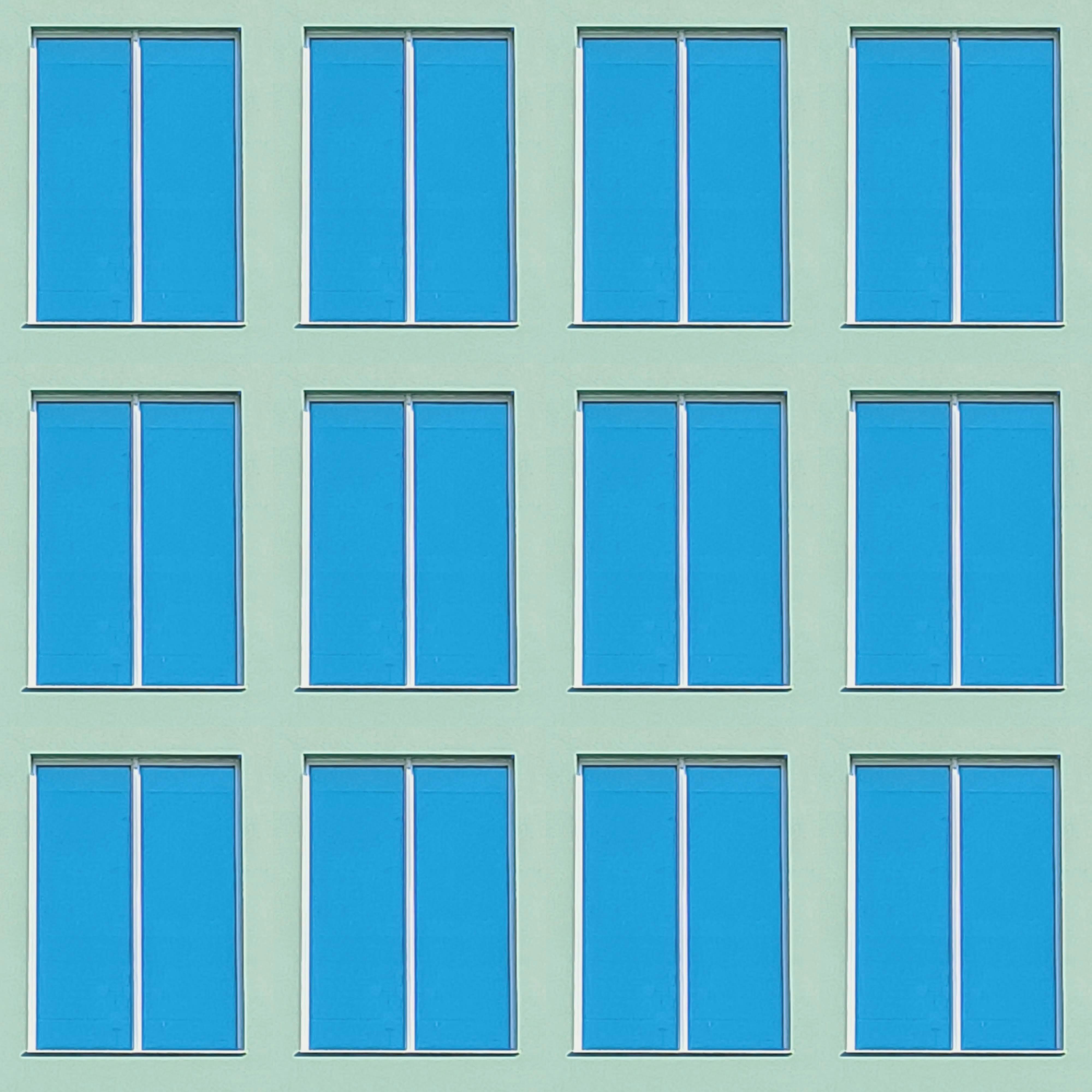 Blue Windows of a Green Building · Free Stock Photo