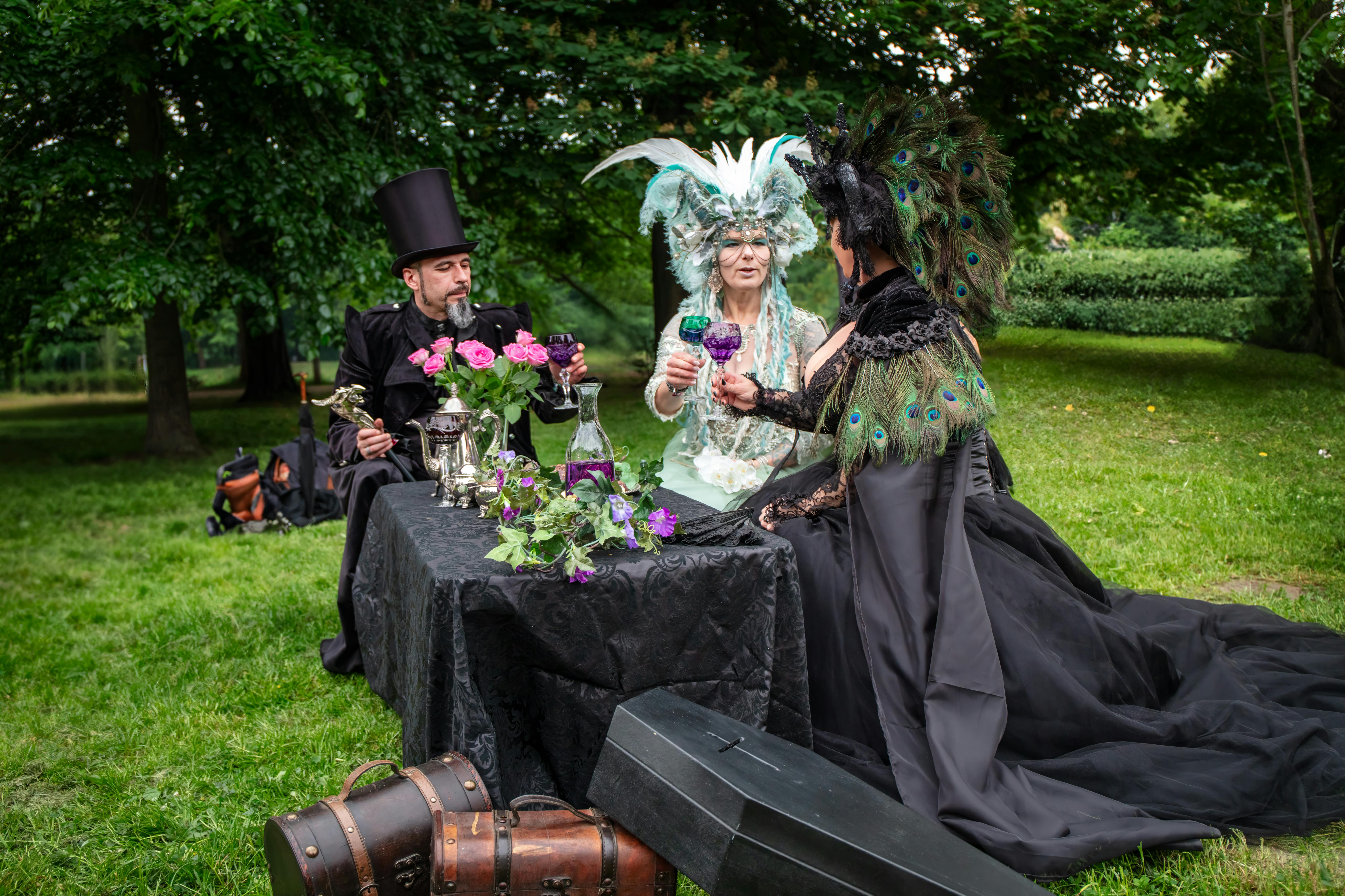 Three people dressed in period costumes sitting on a bench · Free Stock ...