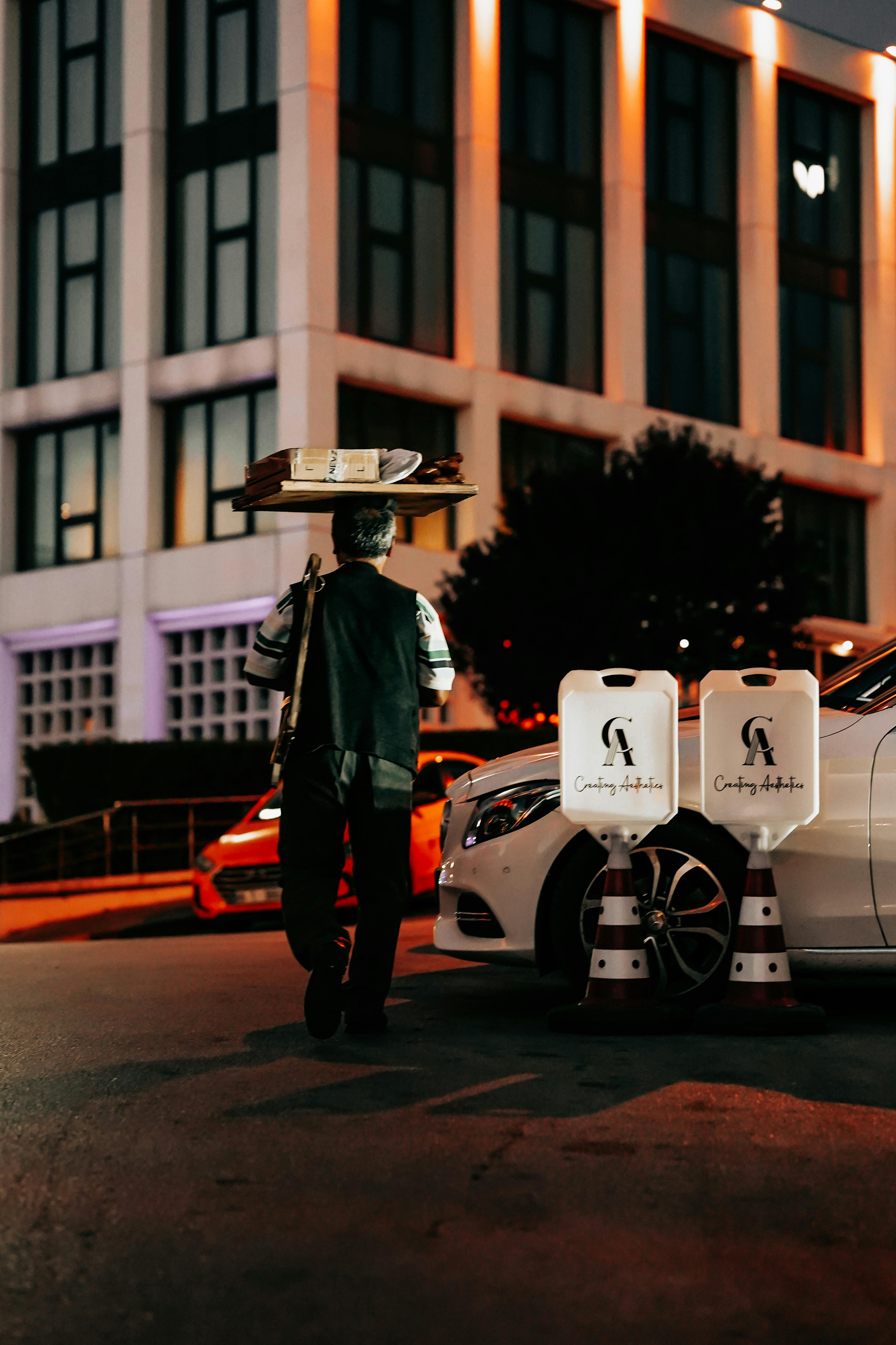Man Carrying Things on Head in City in Evening · Free Stock Photo