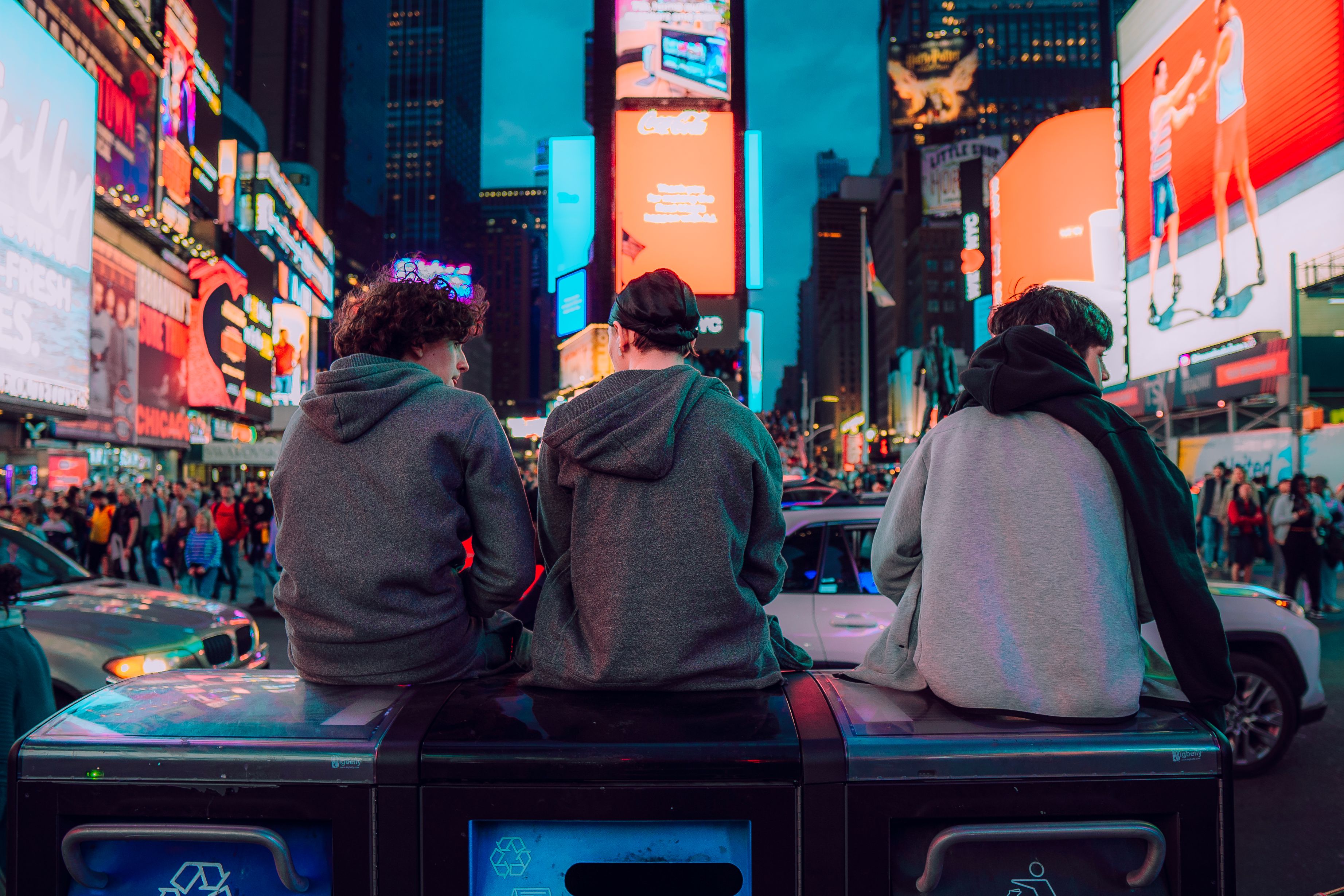 Teenagers Sitting on Garbage Bins on Times Square · Free Stock Photo