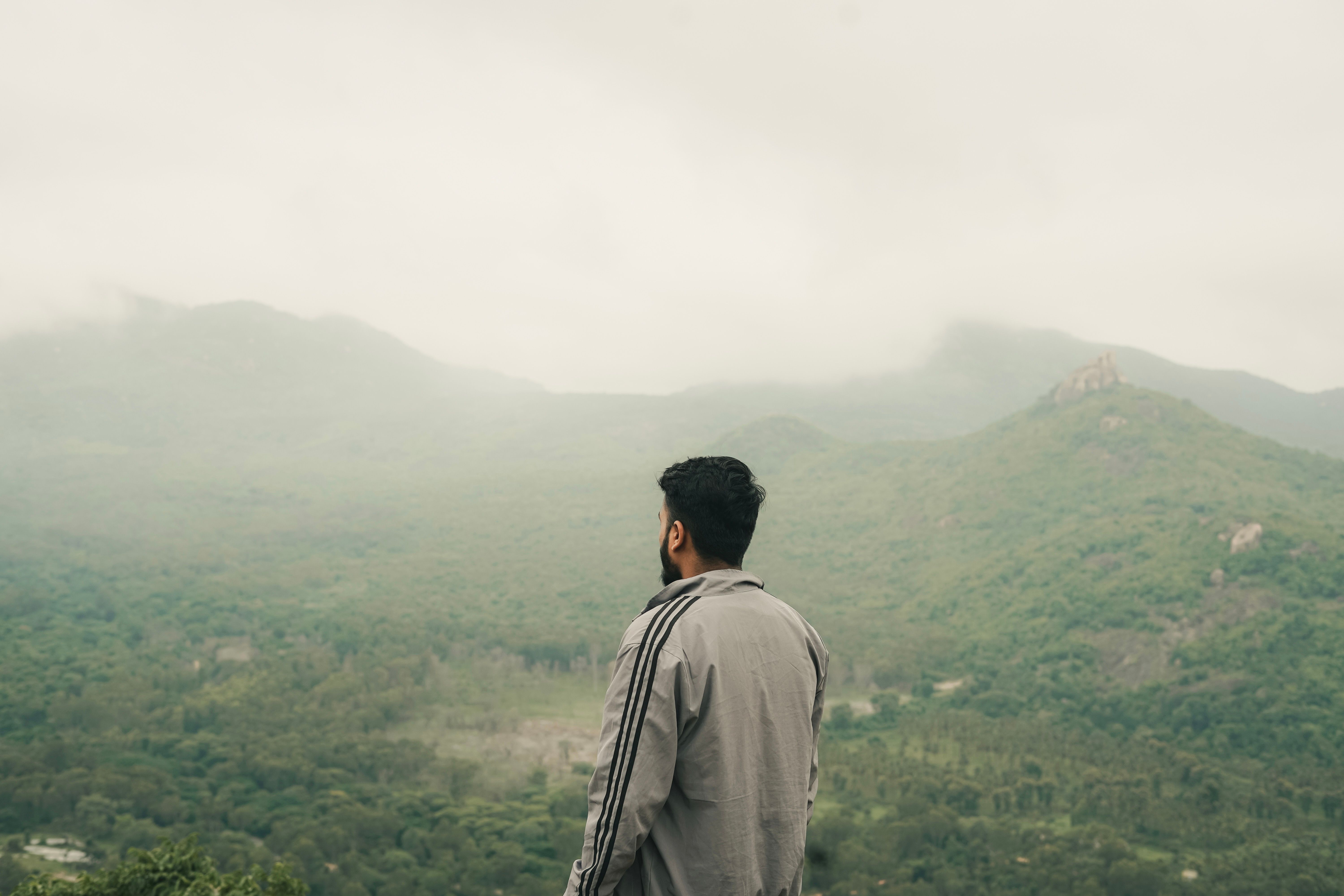 Back View of a Man Looking at Mountains in Fog · Free Stock Photo