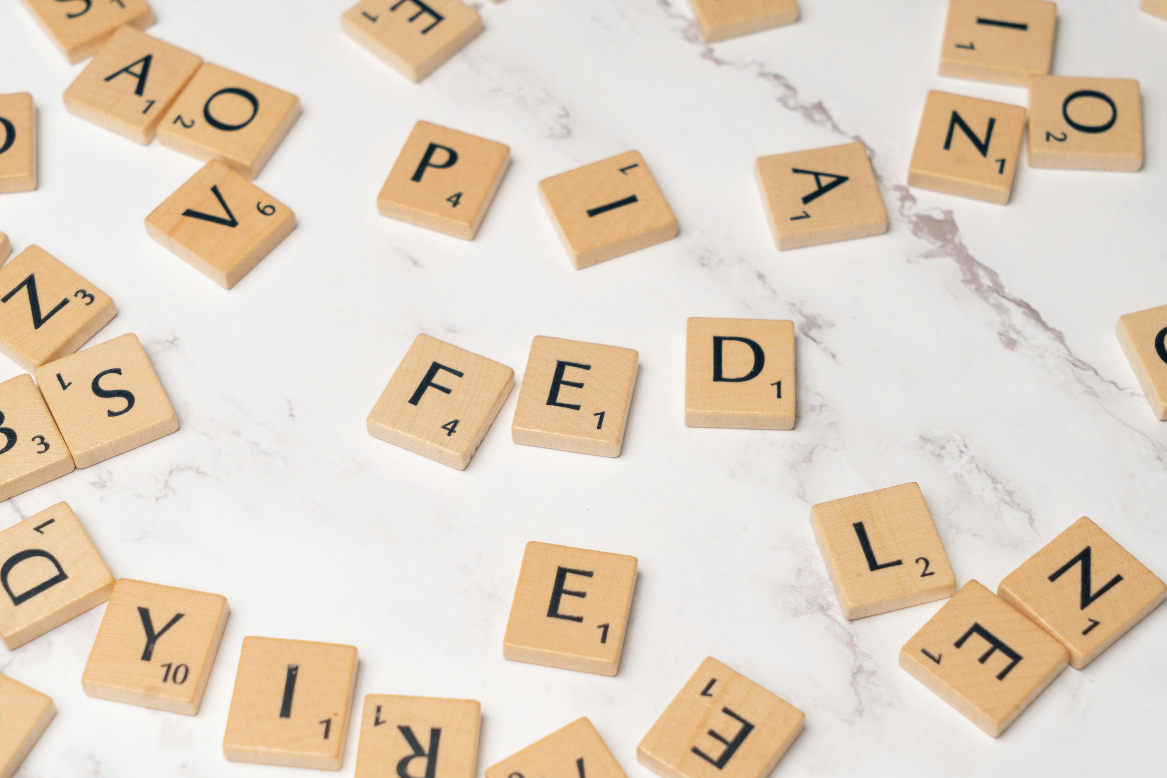Scrabble letters spelling out feed on a marble surface · Free Stock Photo