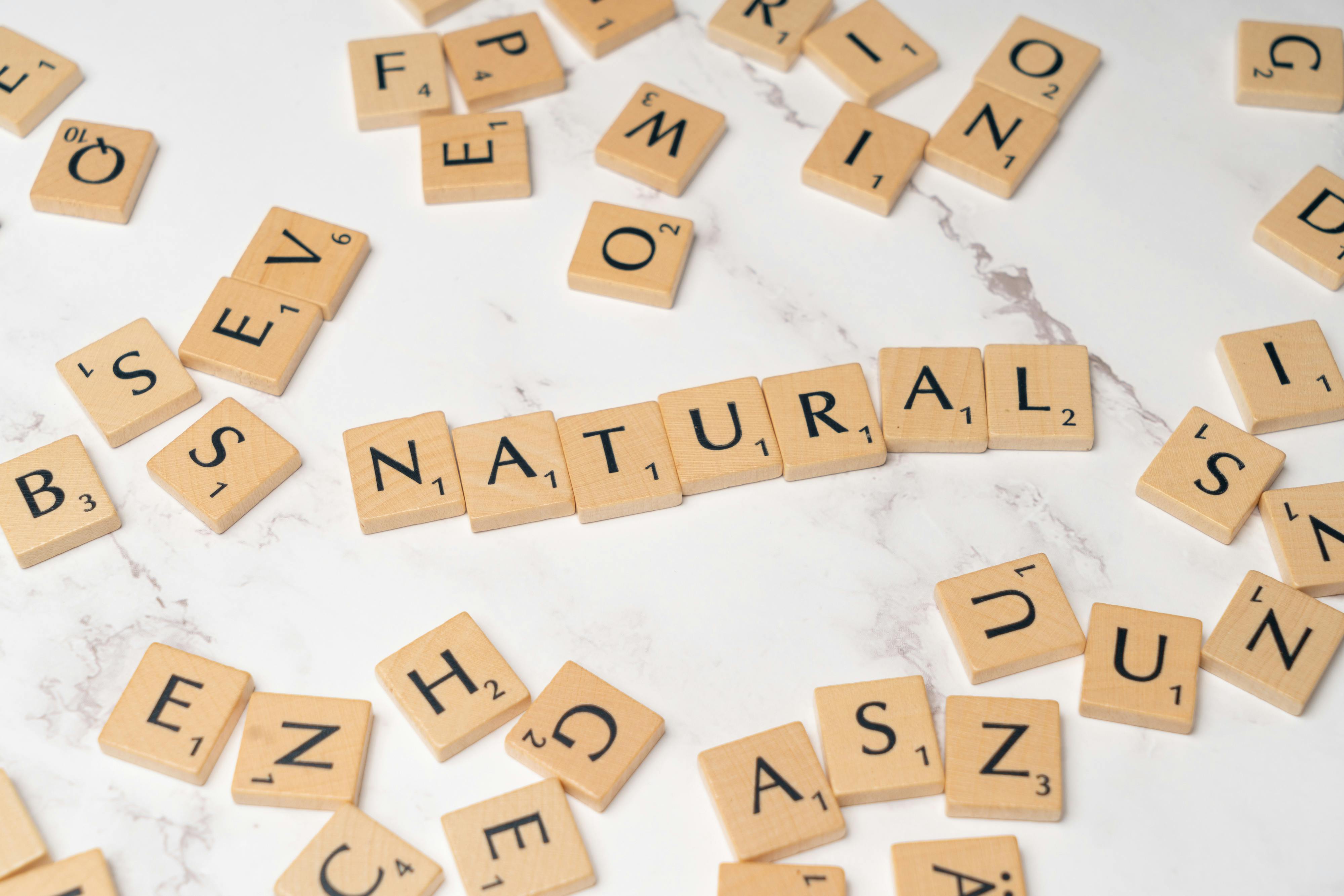 Natural scrabble letters on a white table · Free Stock Photo