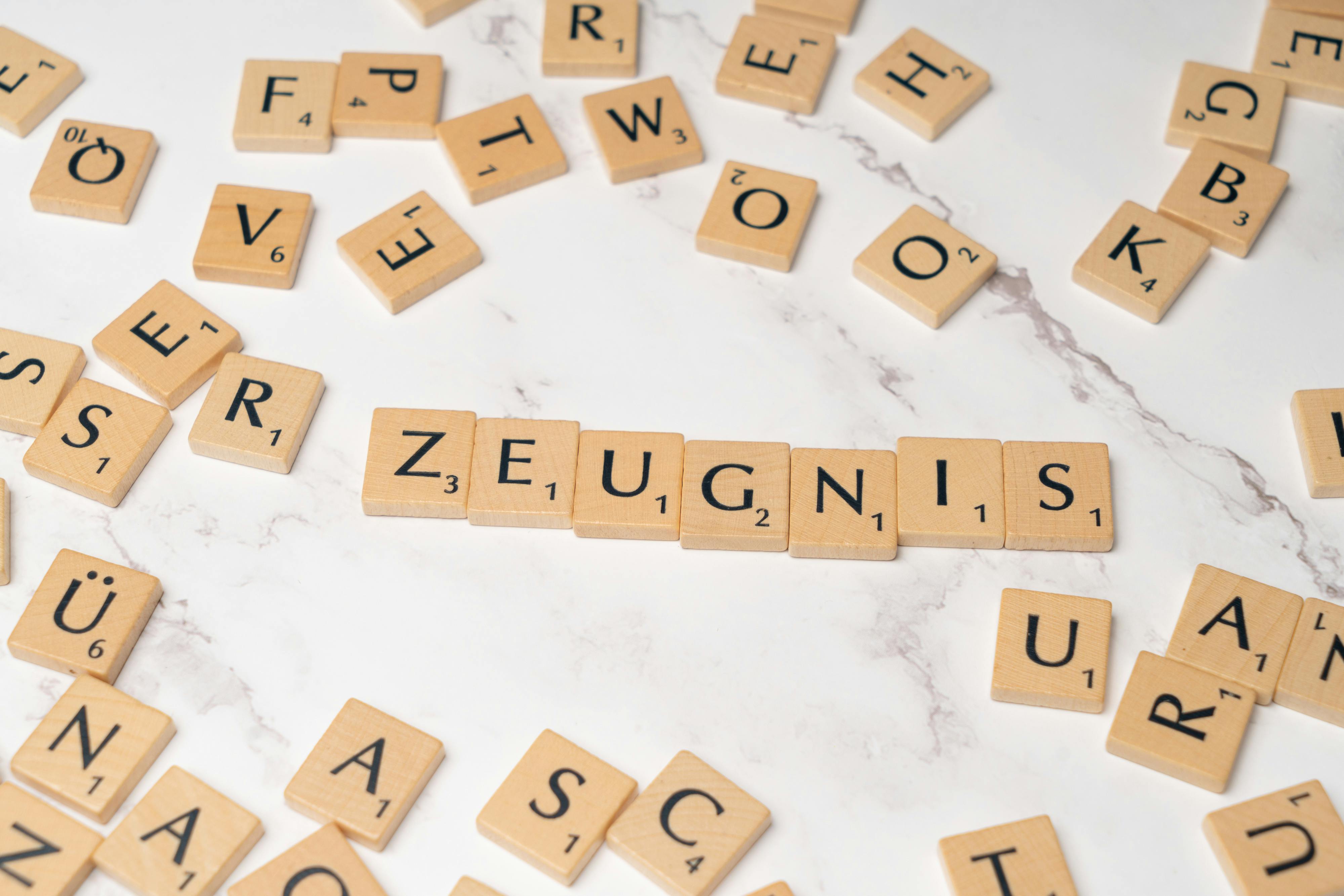 Scrabble tiles spelling zugunis on a marble table · Free Stock Photo