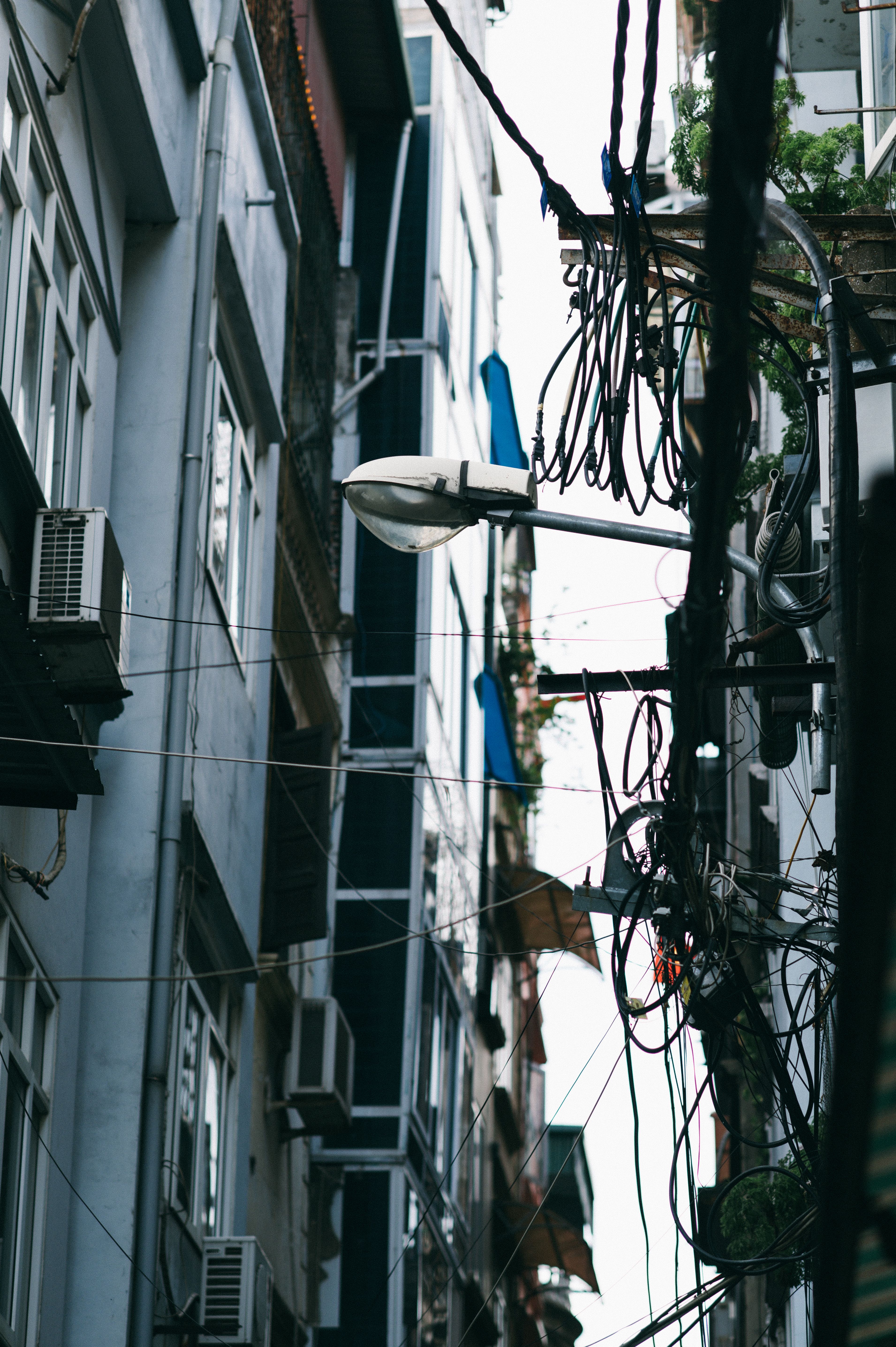 Street Lamp and Power Lines between Buildings Walls · Free Stock Photo