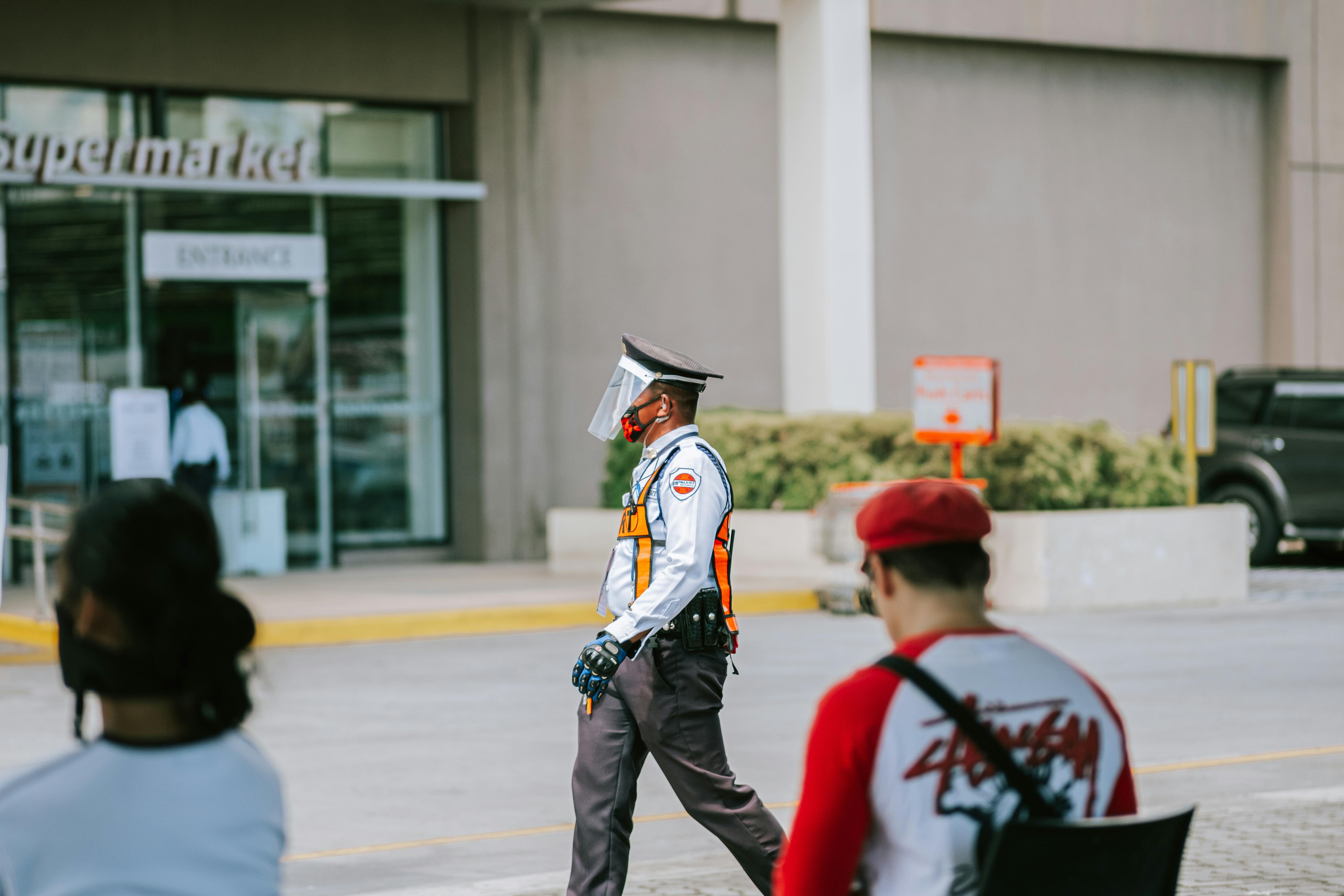 Security Guard Walking on Street near Building in City · Free Stock Photo