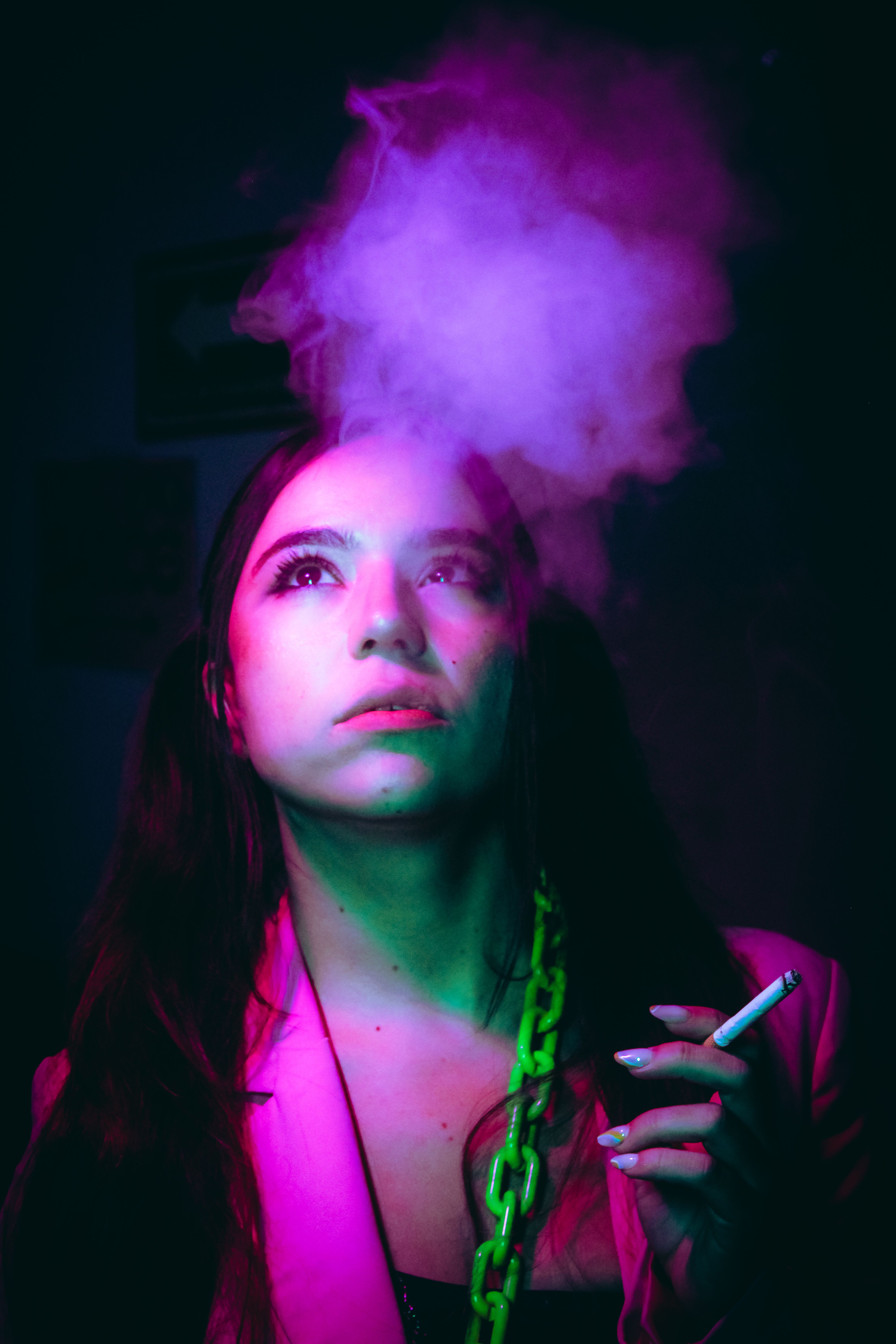 A woman smoking a cigarette in a dark room · Free Stock Photo