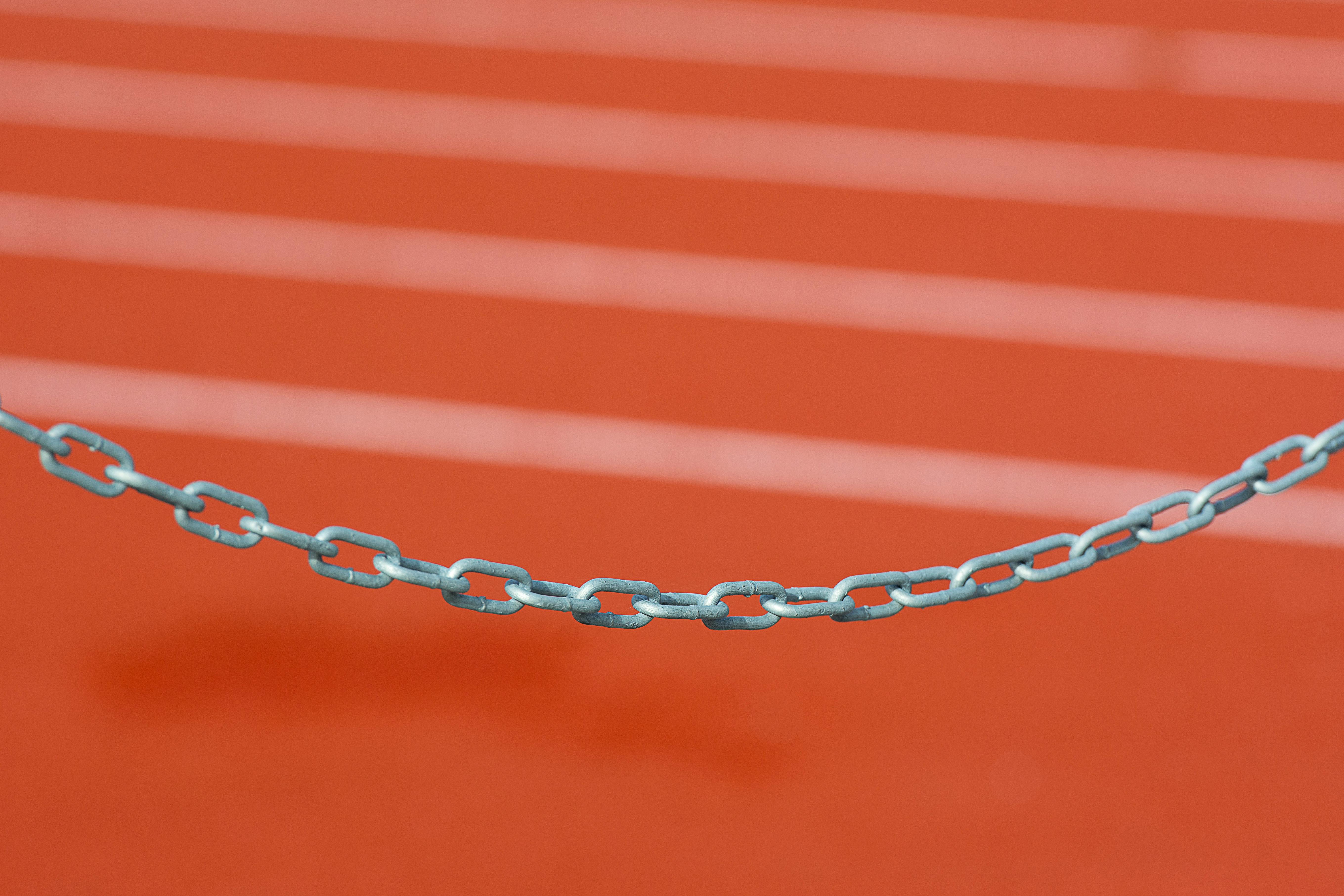 Stainless Steel Chain against Red Background · Free Stock Photo
