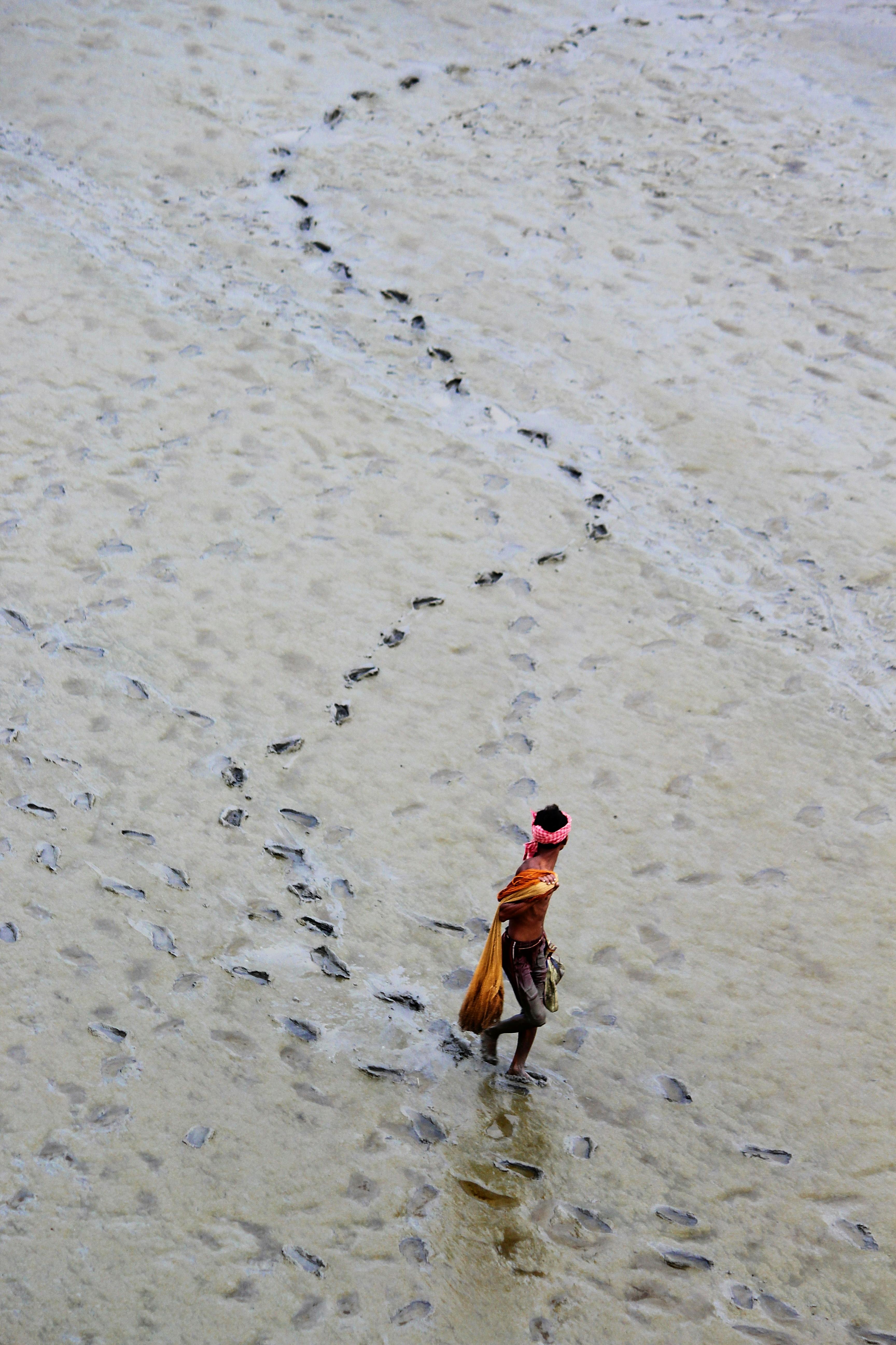 Aerial View of a Person Walking on a Beach Leaving Footprints Behind ...
