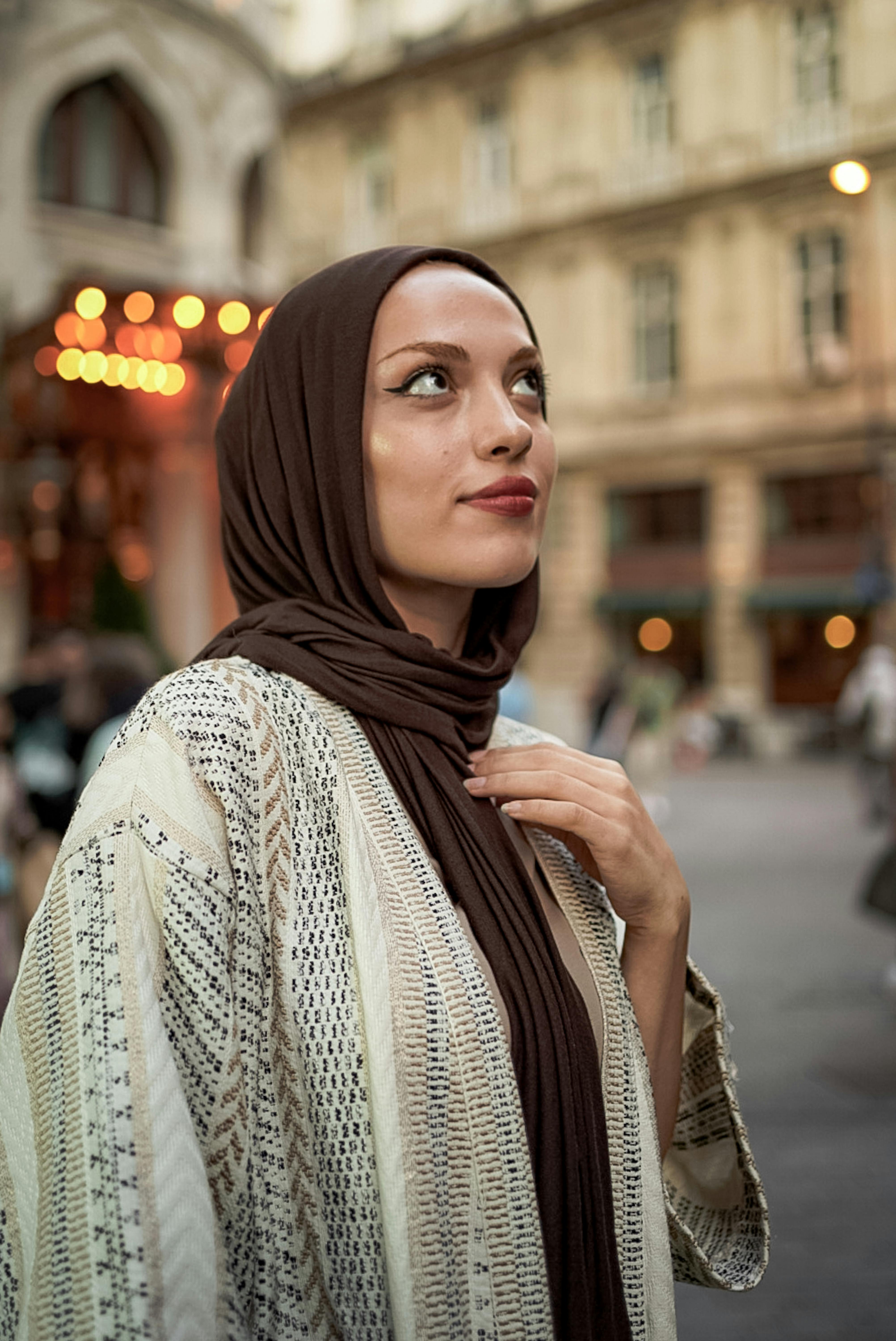 Young Woman in a Hijab Holding a Fabric Fan to Cover Half of Her Face ...