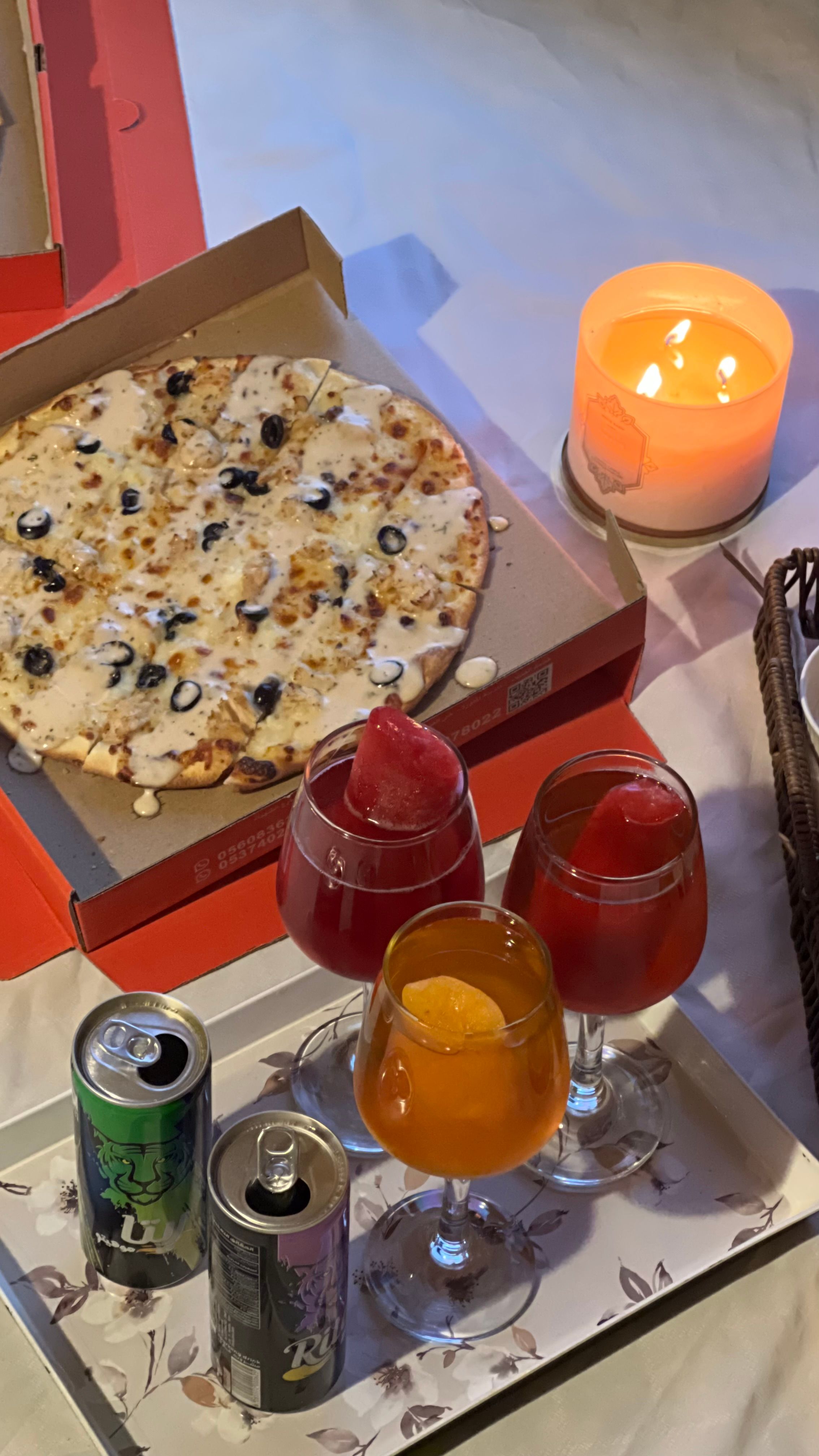 A pizza and drinks are on a tray with a candle · Free Stock Photo