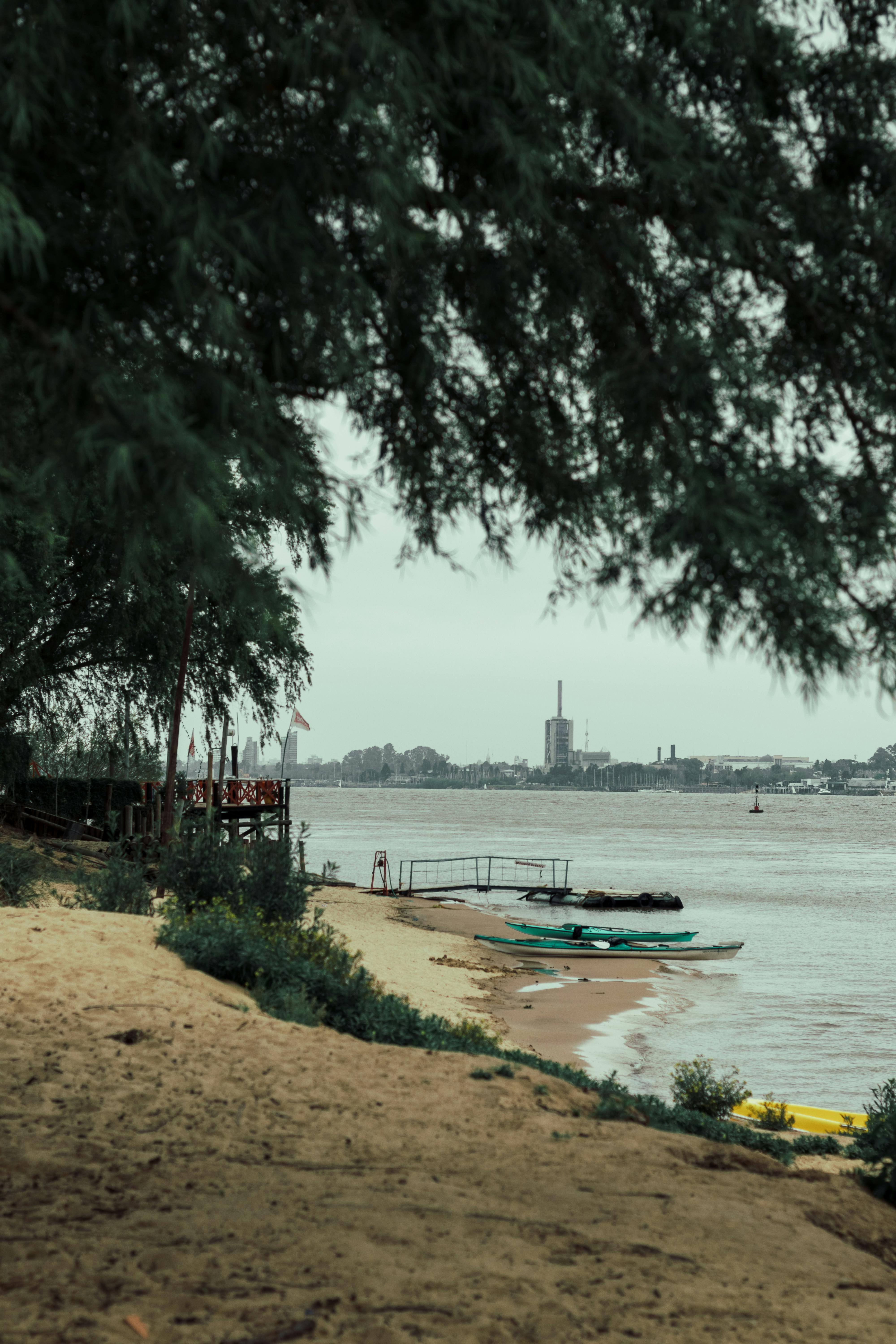 Beach on Riverbank with City behind · Free Stock Photo