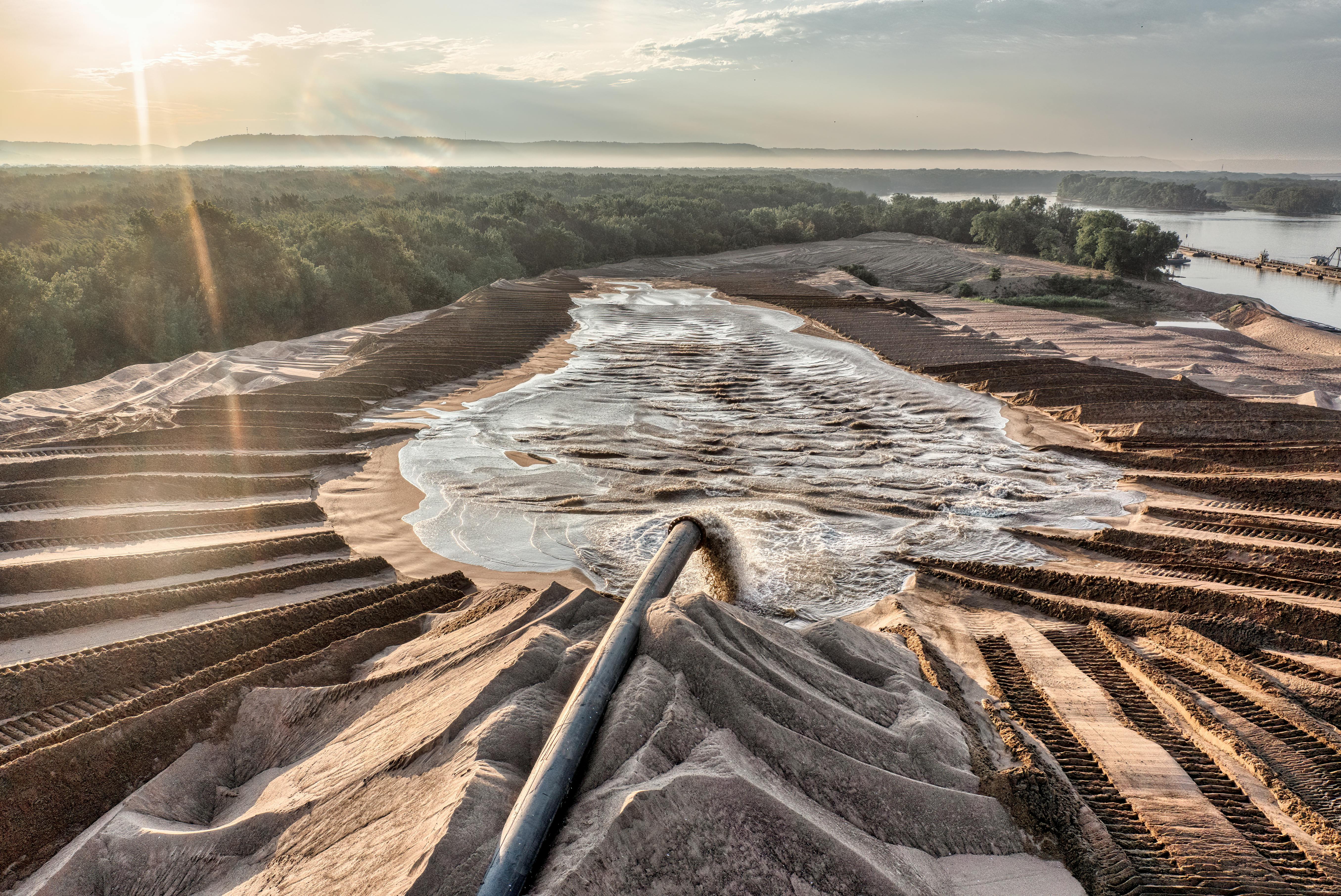 Flowing Water from Pipe on Sand near Forest · Free Stock Photo