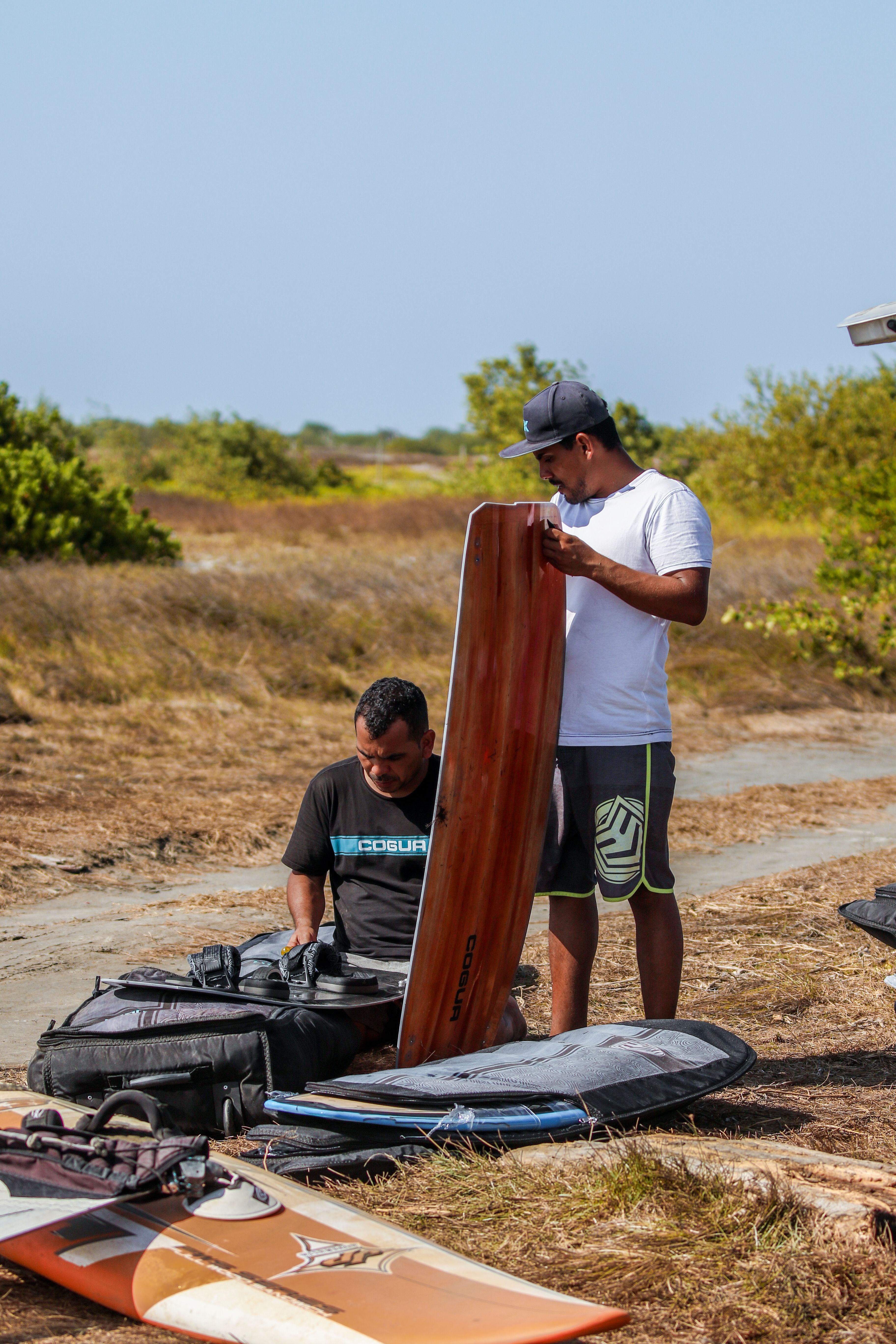 Two men are working on a surfboard · Free Stock Photo