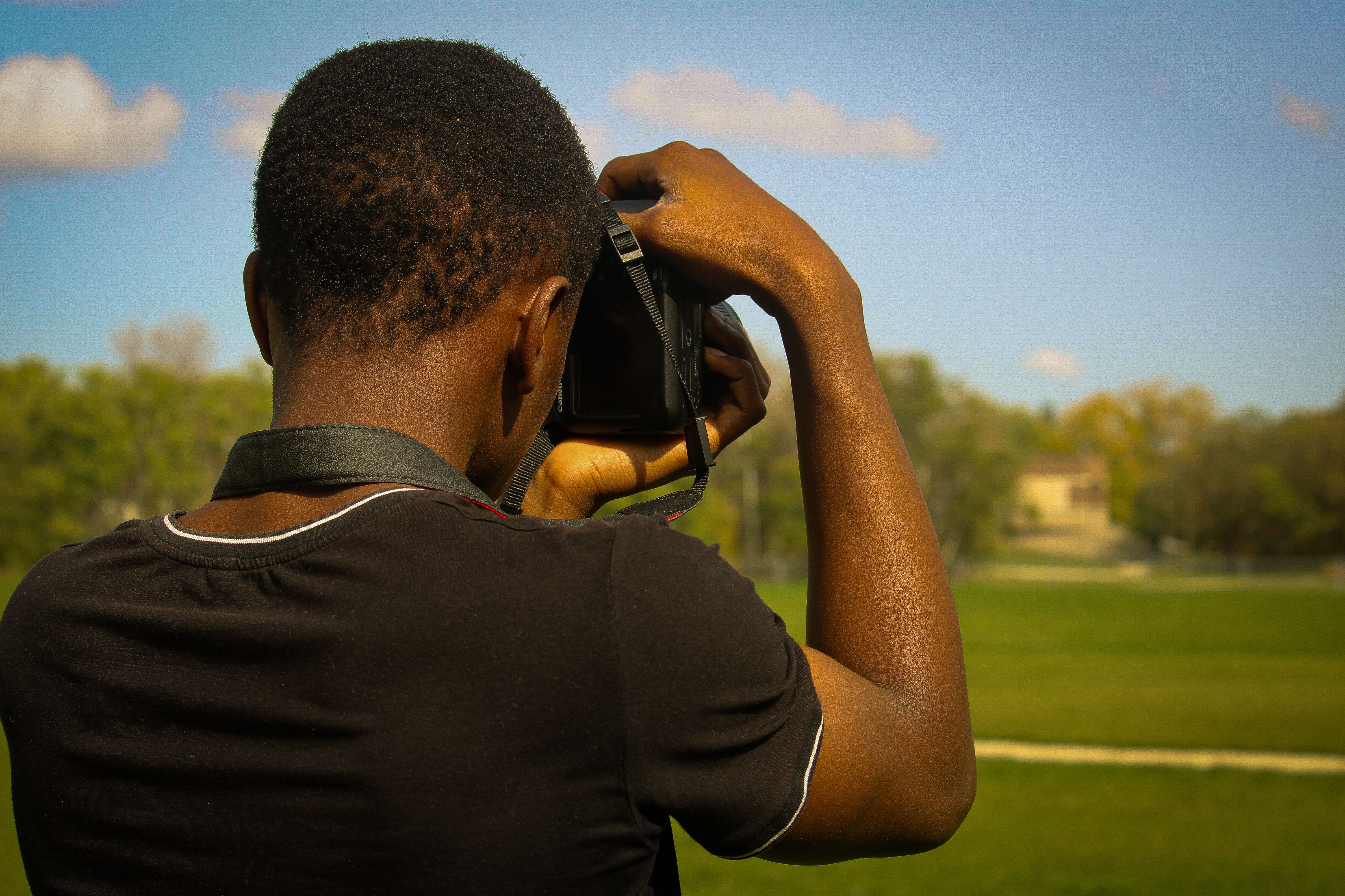 Man Photographing a Meadow with a Camera · Free Stock Photo