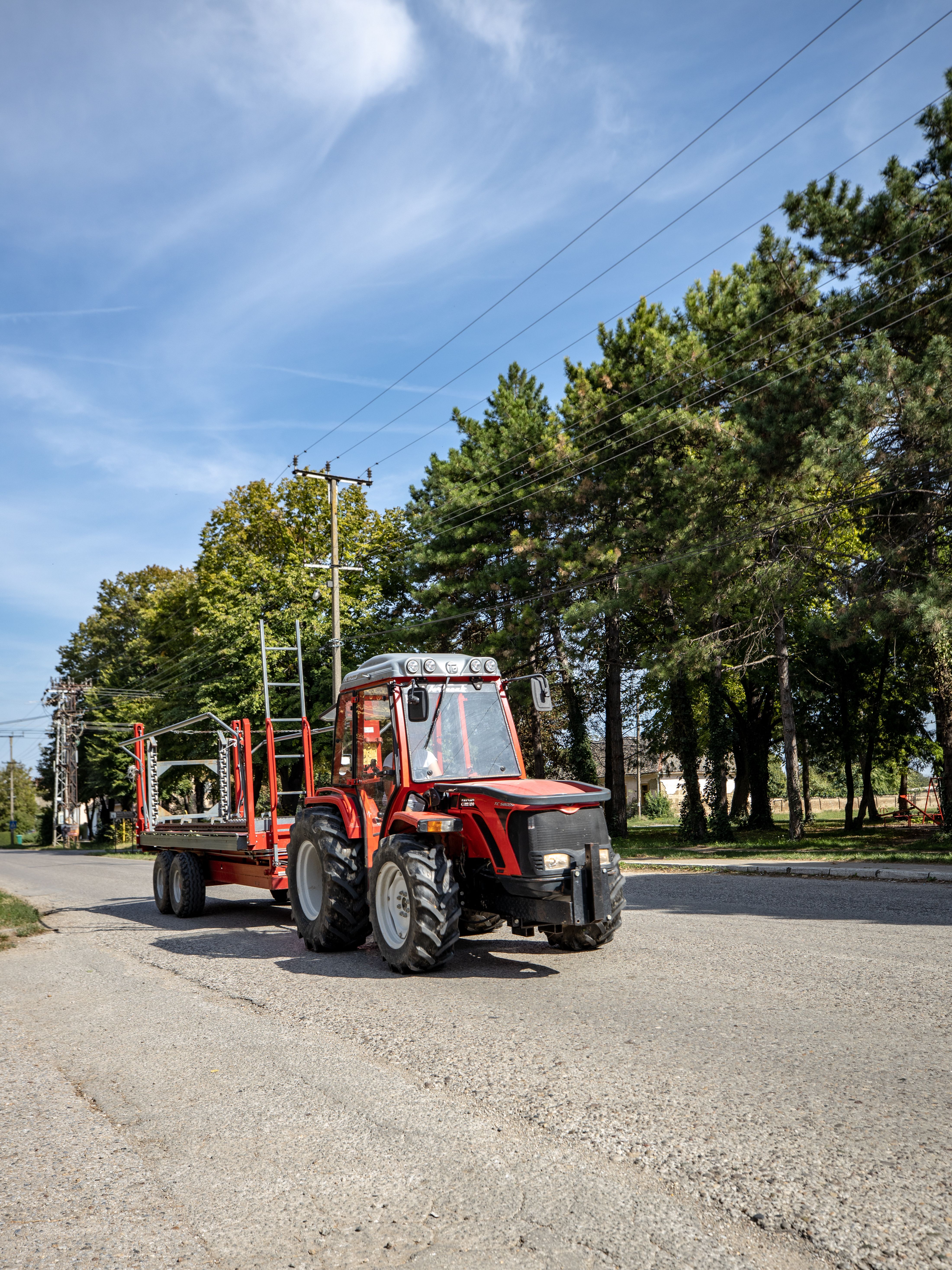 A tractor is pulling a trailer on the road · Free Stock Photo