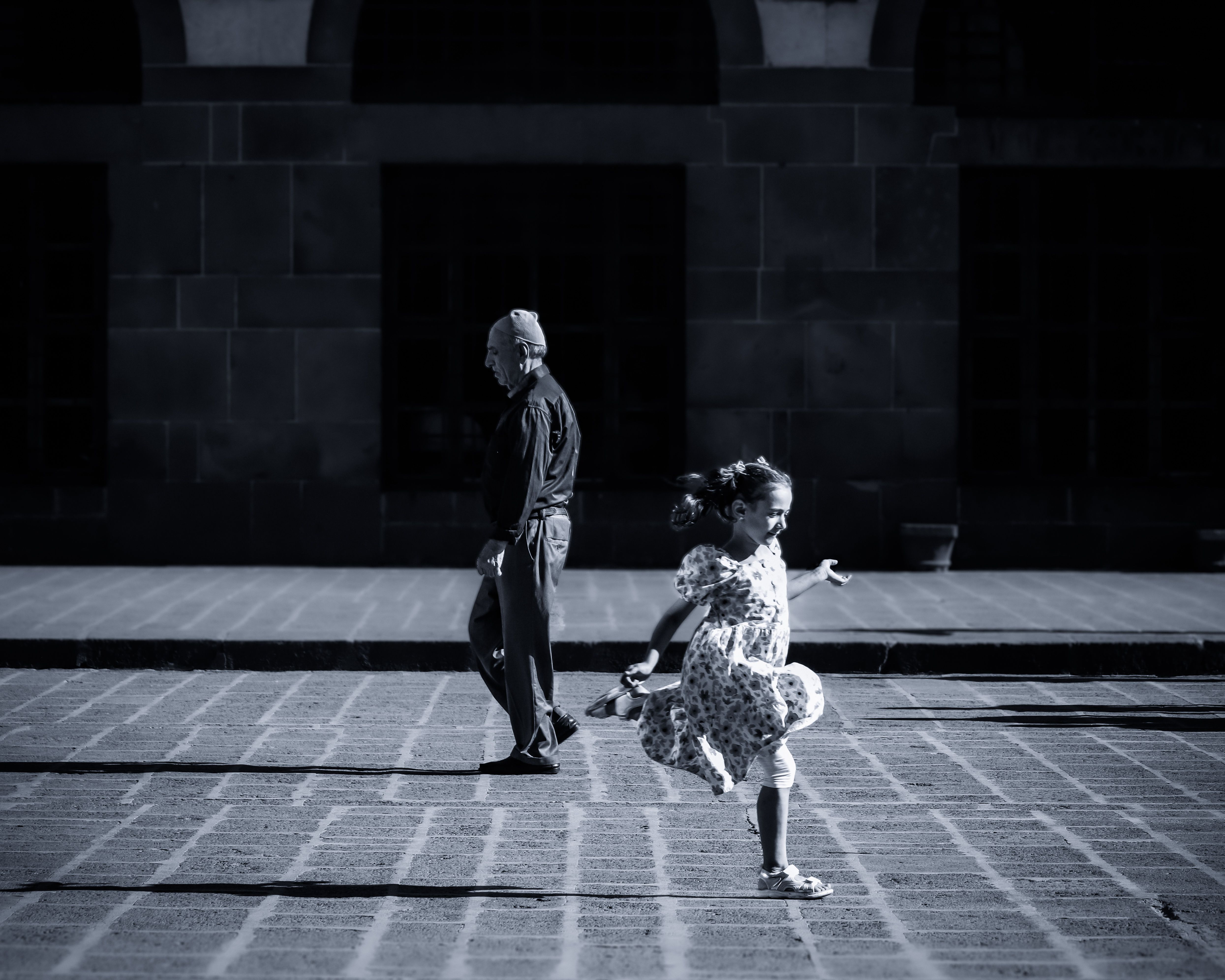 Girl in Sundress Running on Pavement in Black and White · Free Stock Photo