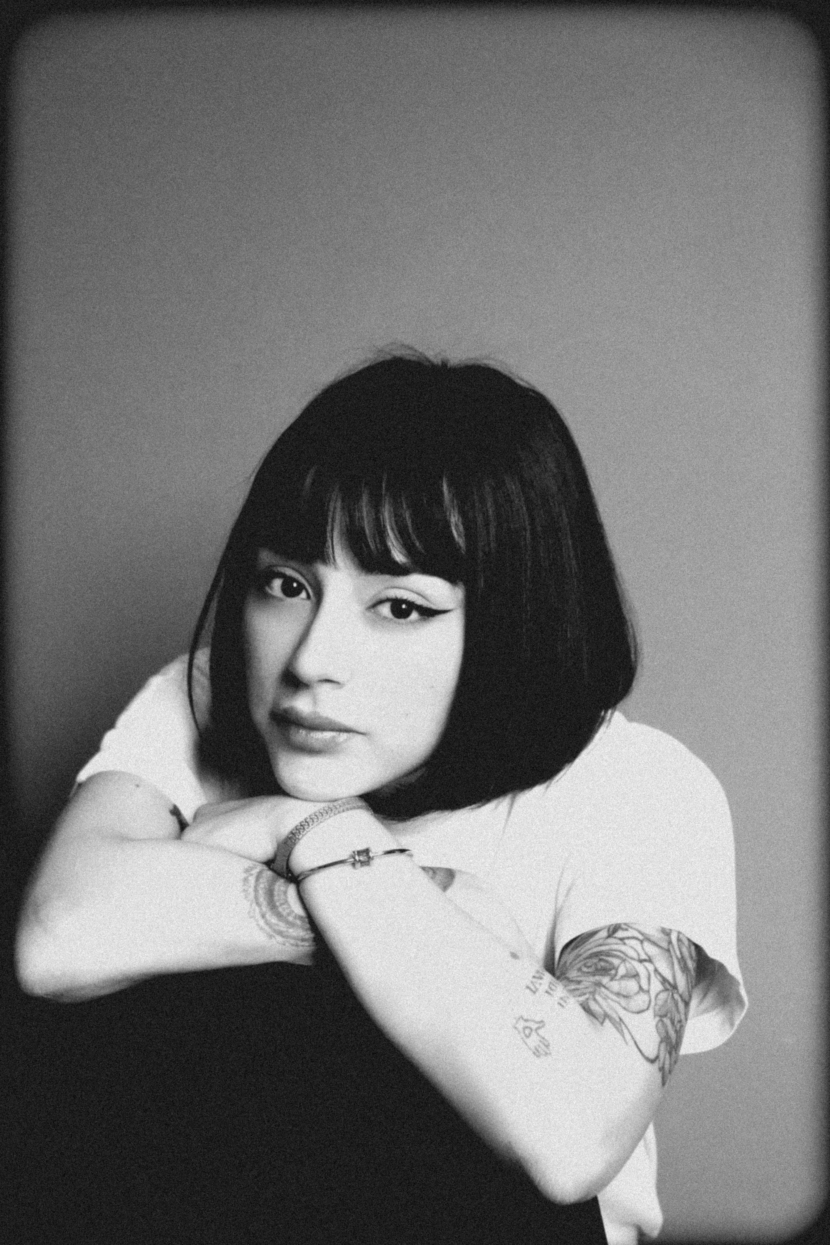 Woman with Tattoos Sitting and Posing in Black and White · Free Stock Photo