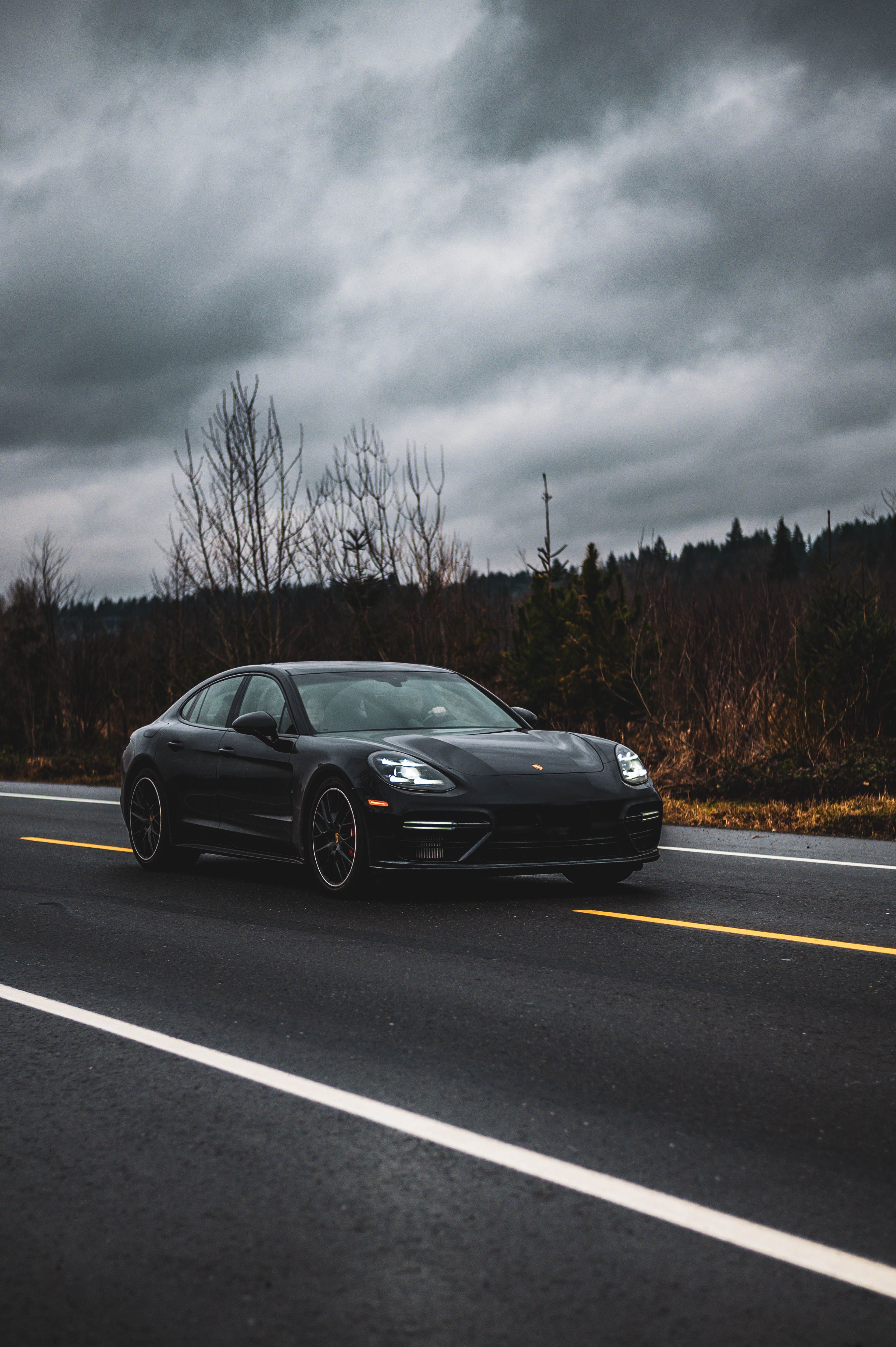 A black sports car driving on a road · Free Stock Photo