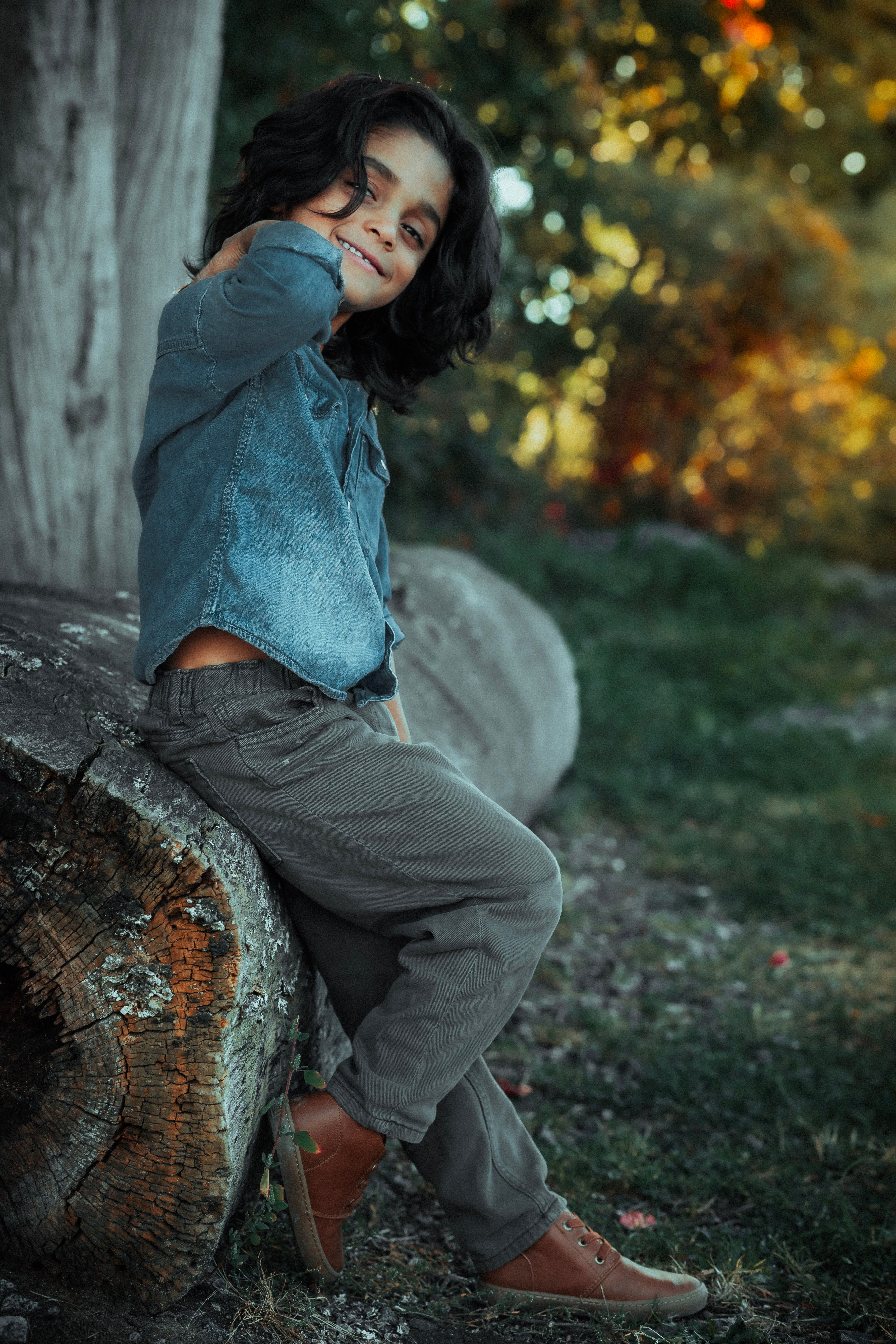 Boy Leaning against a Felled Tree · Free Stock Photo