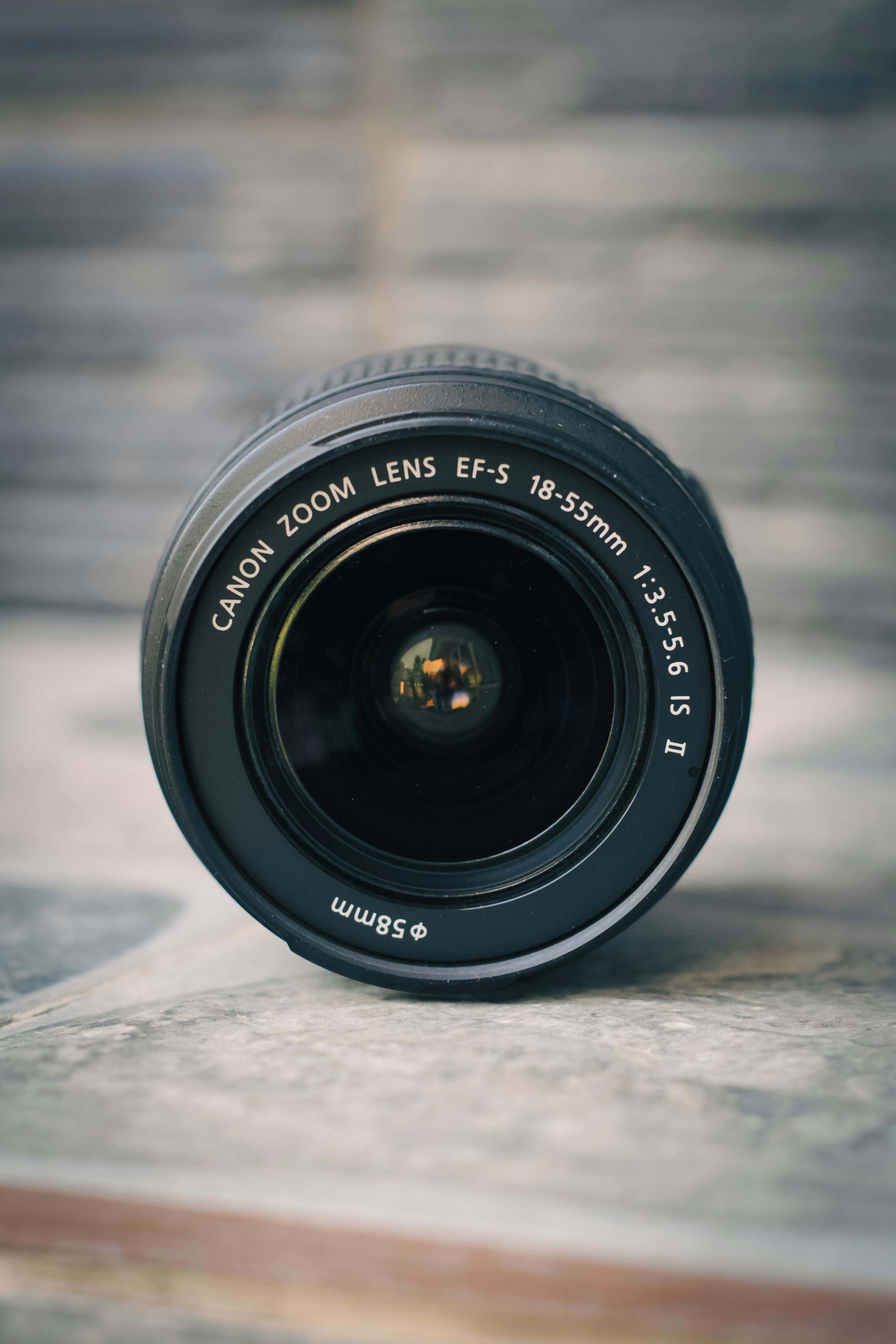 Black Canon Zoom Lens Leaning on Book · Free Stock Photo