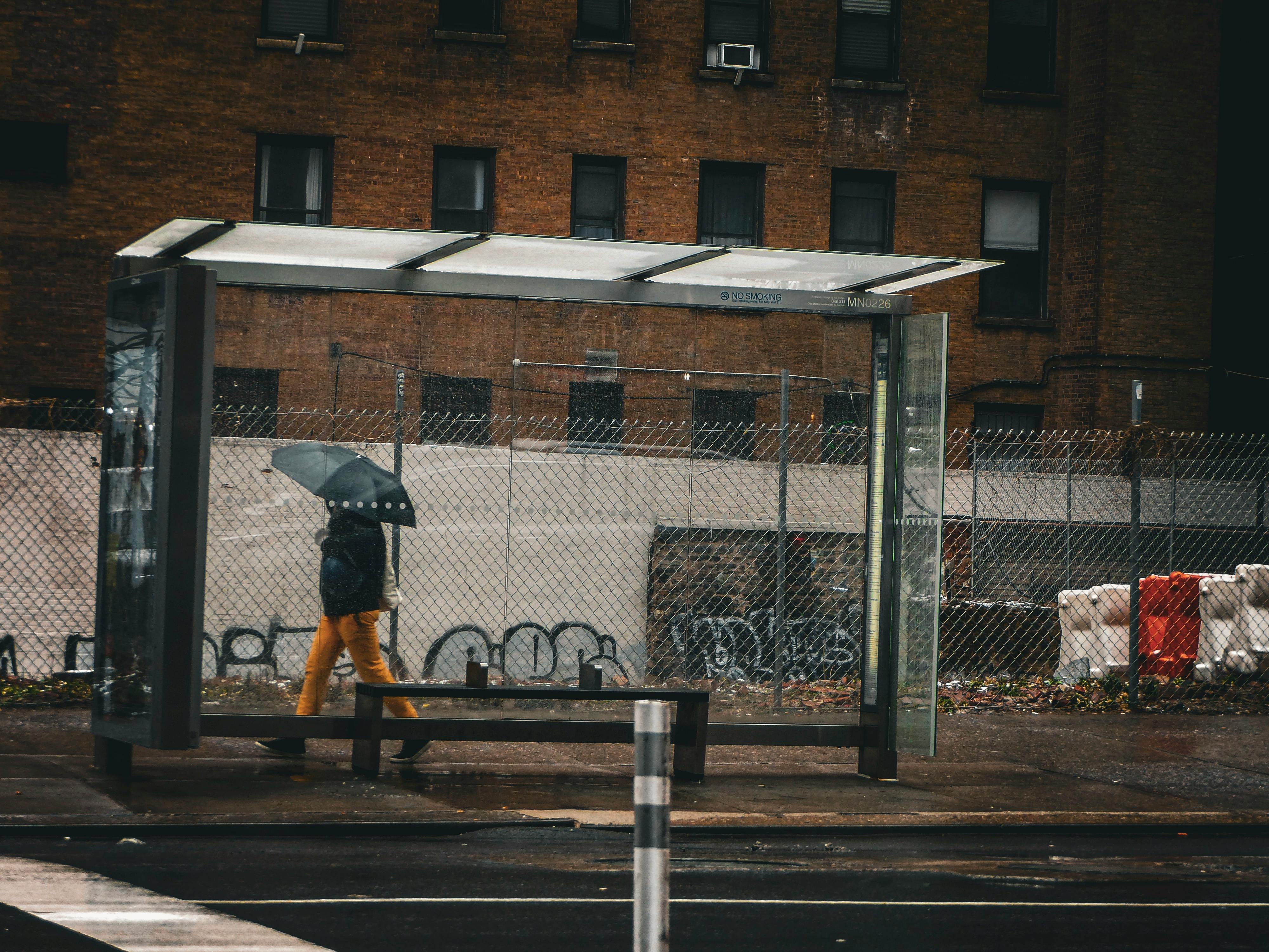 Person with Umbrella Passing Empty Bus Stop in Industrial District ...