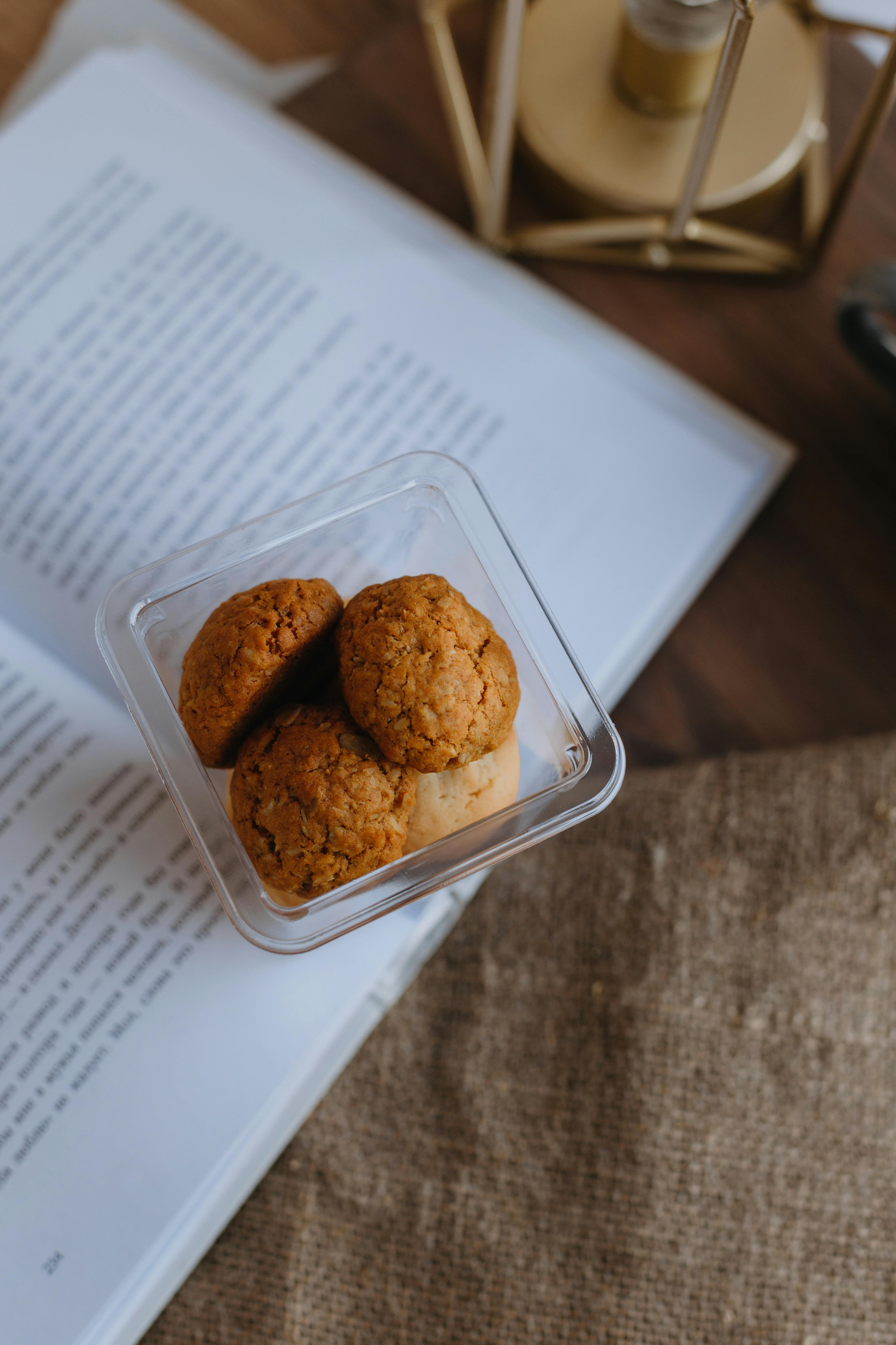 A small container of cookies sitting on top of a book · Free Stock Photo