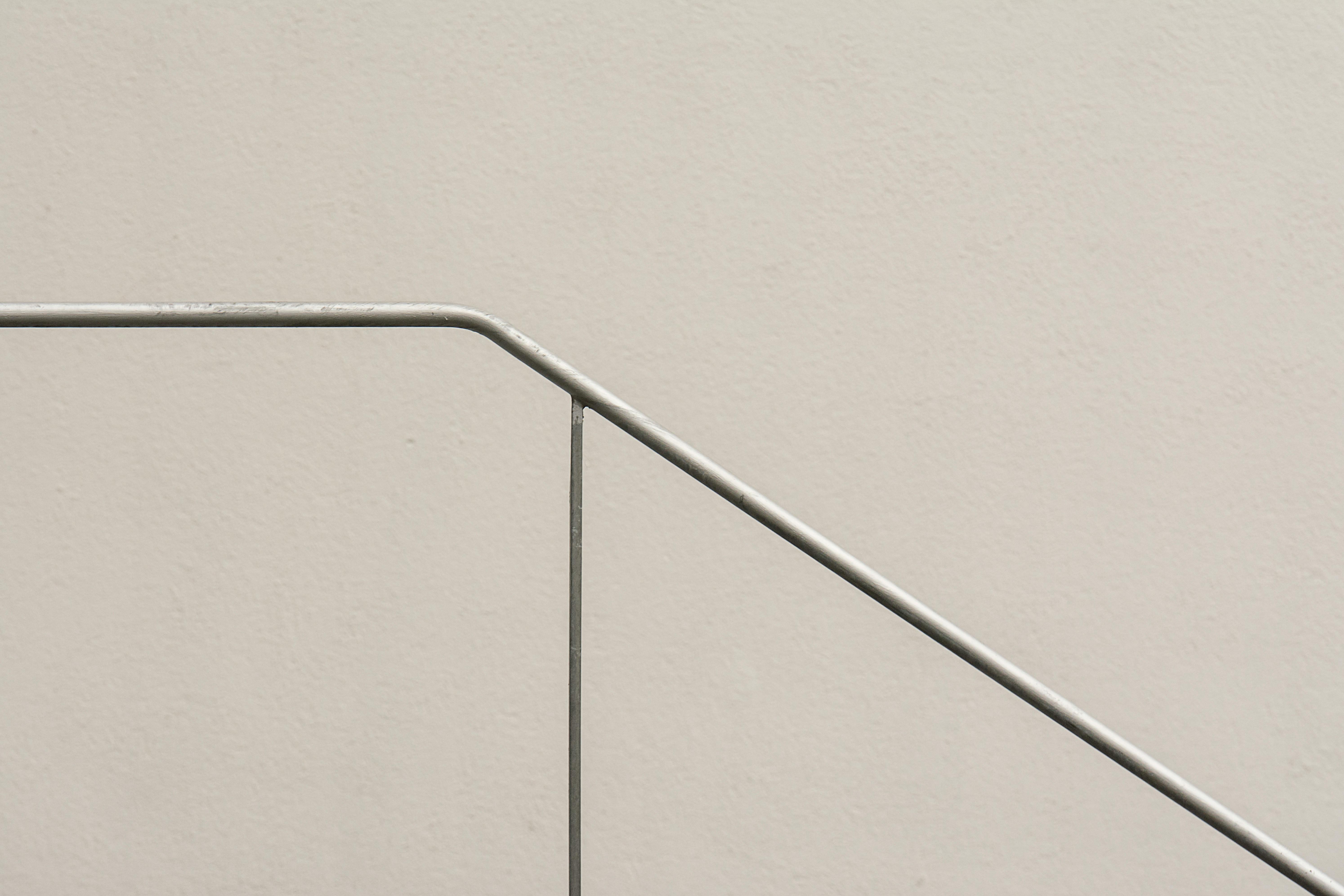 A white wall with a metal railing · Free Stock Photo