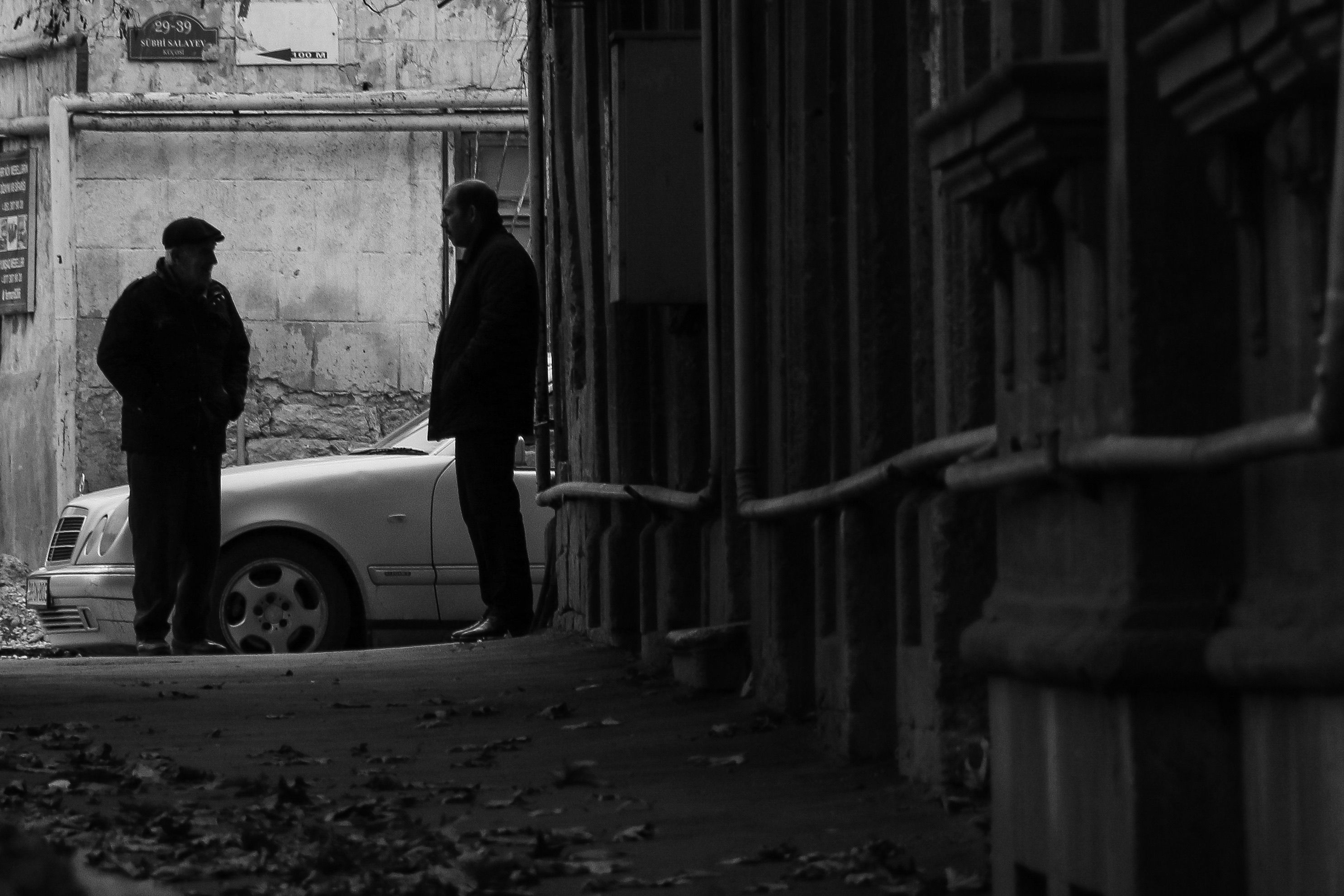 Two men stand in the alleyway of a building · Free Stock Photo