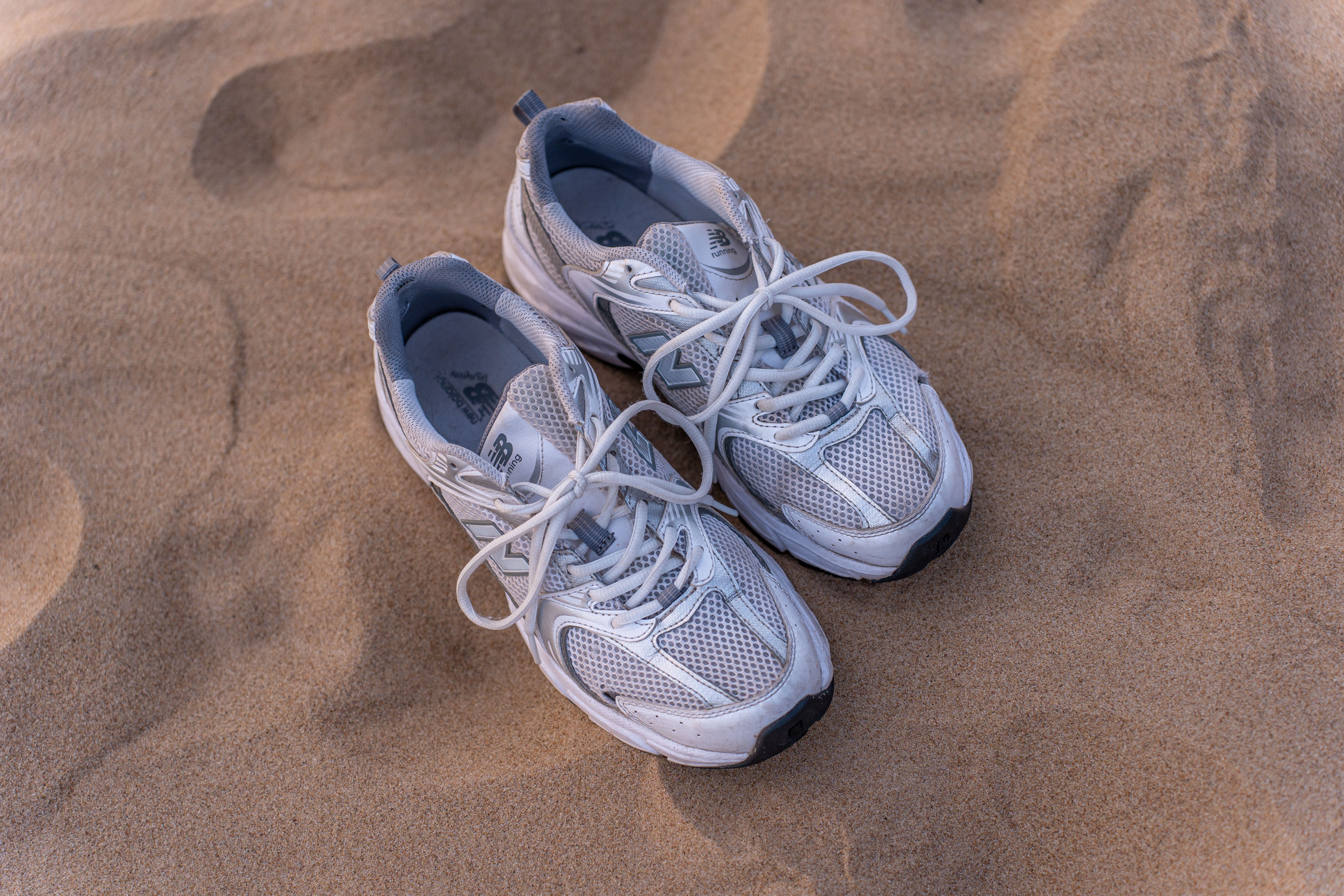 White New Balance Sneakers Standing on a Beach · Free Stock Photo