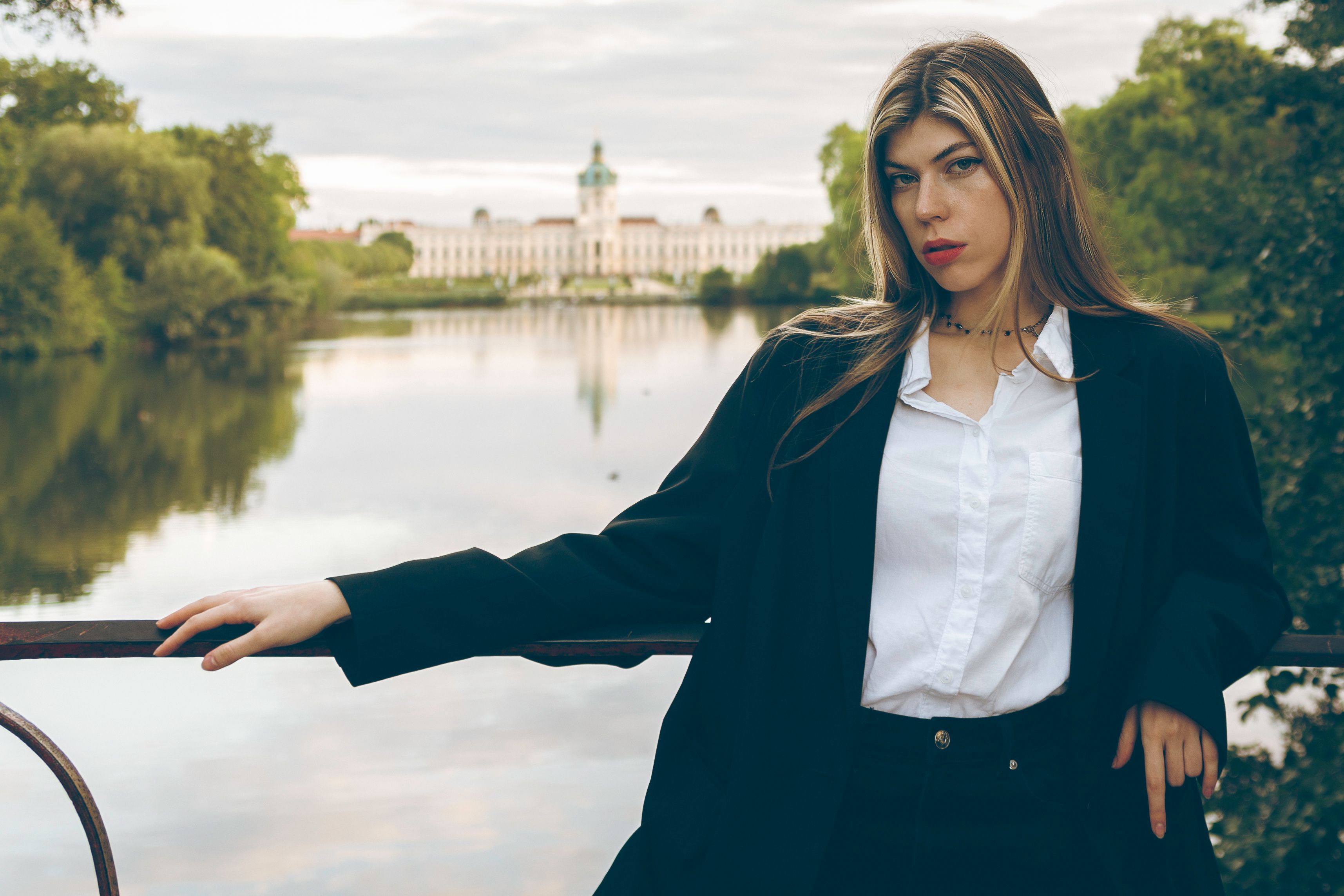 A woman in a business suit standing on a bridge · Free Stock Photo
