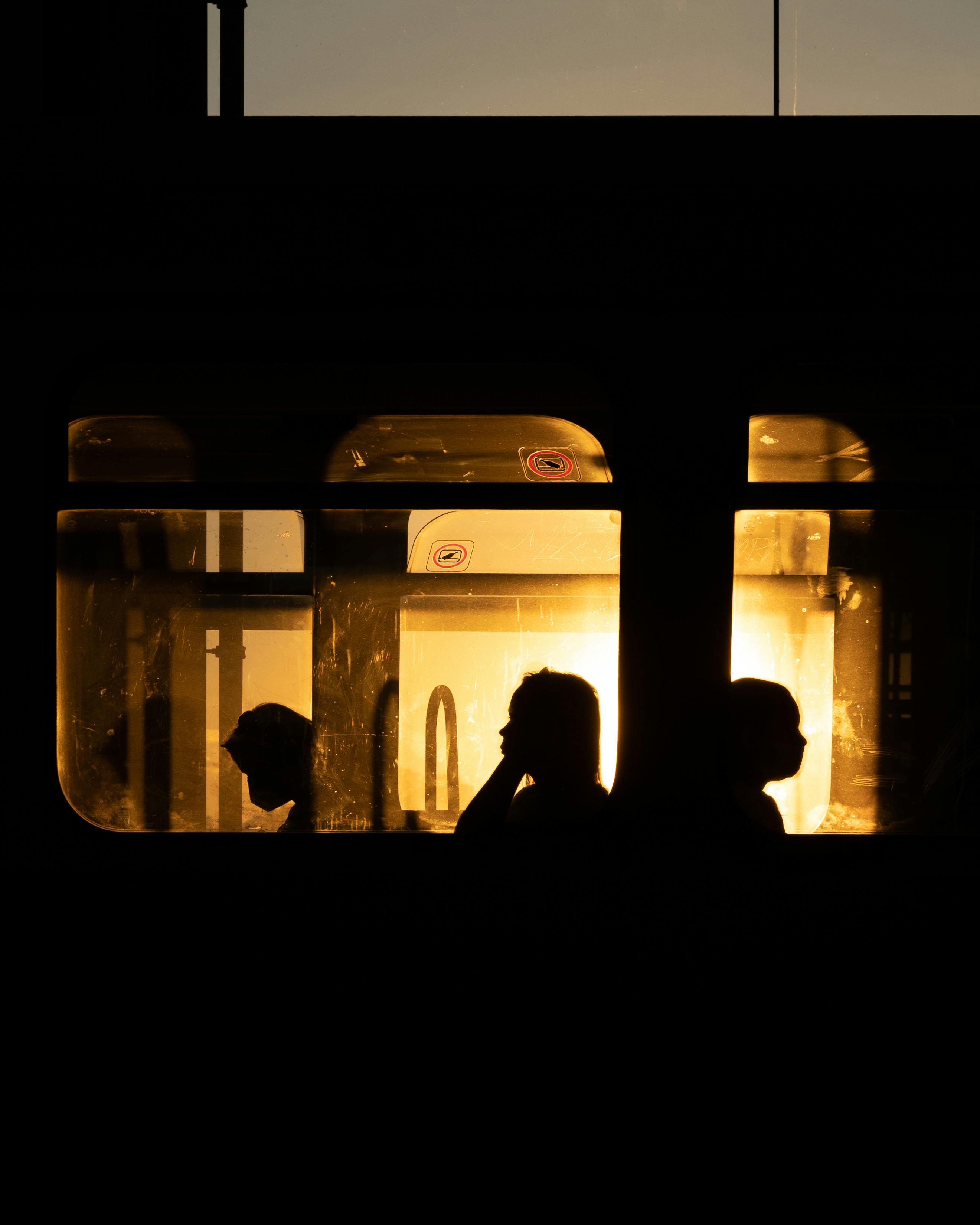 Silhouette of People behind Train Windows at Sunset · Free Stock Photo