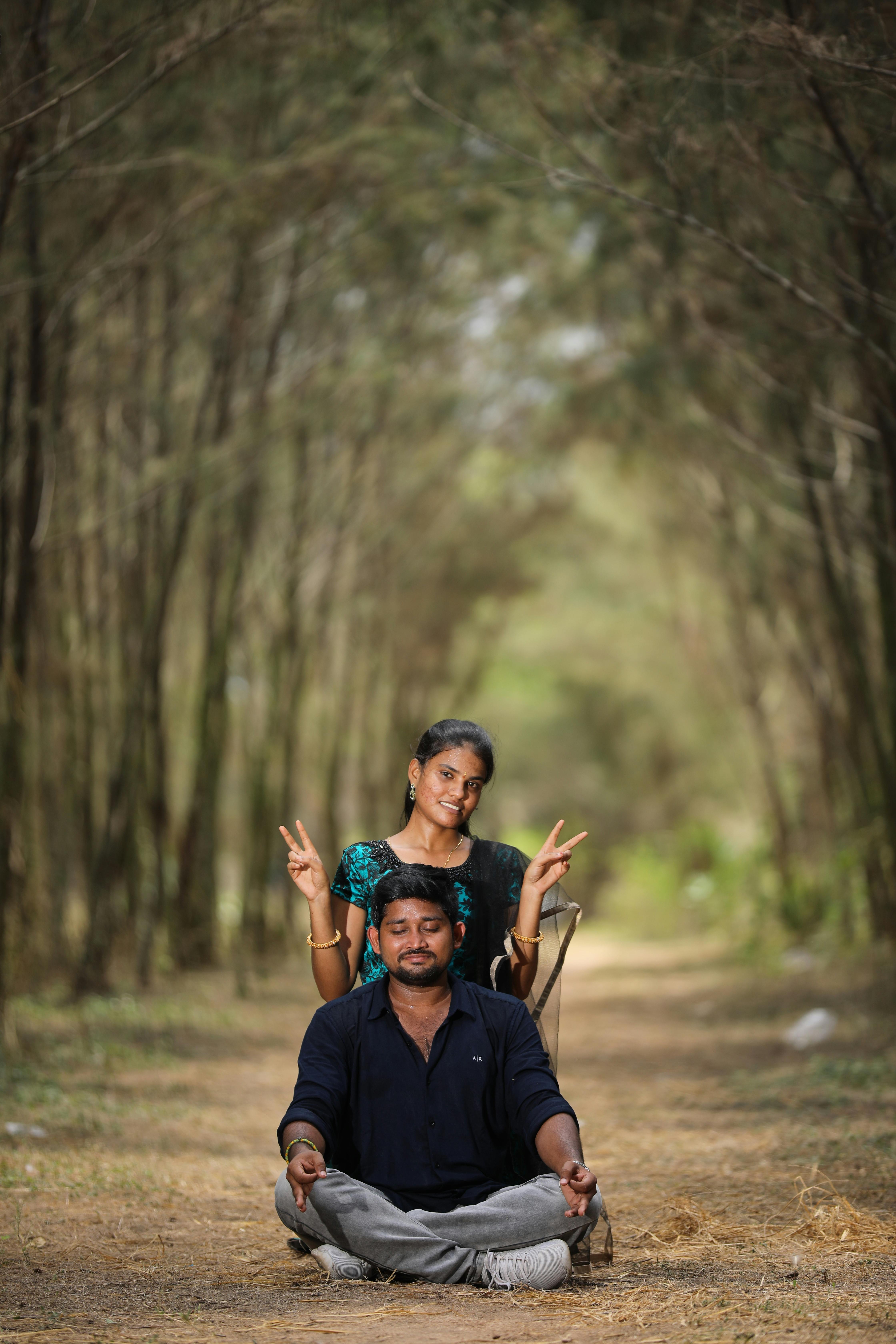 Woman Showing V-sign Gesture Behind Her Boyfriend Back Meditating on a ...