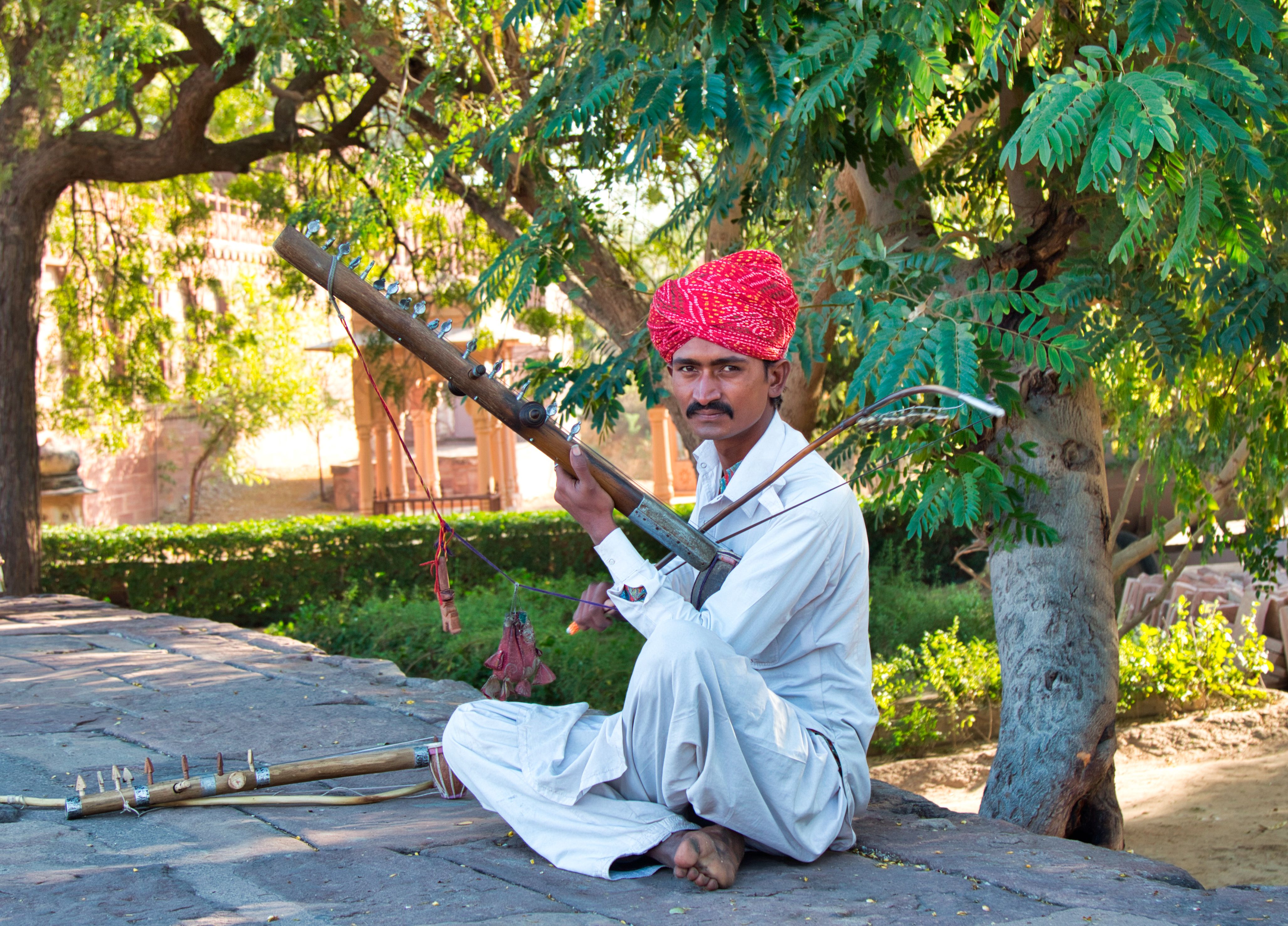 Photo of a Man Wearing Traditional Clothing Sitting in a Park with a ...