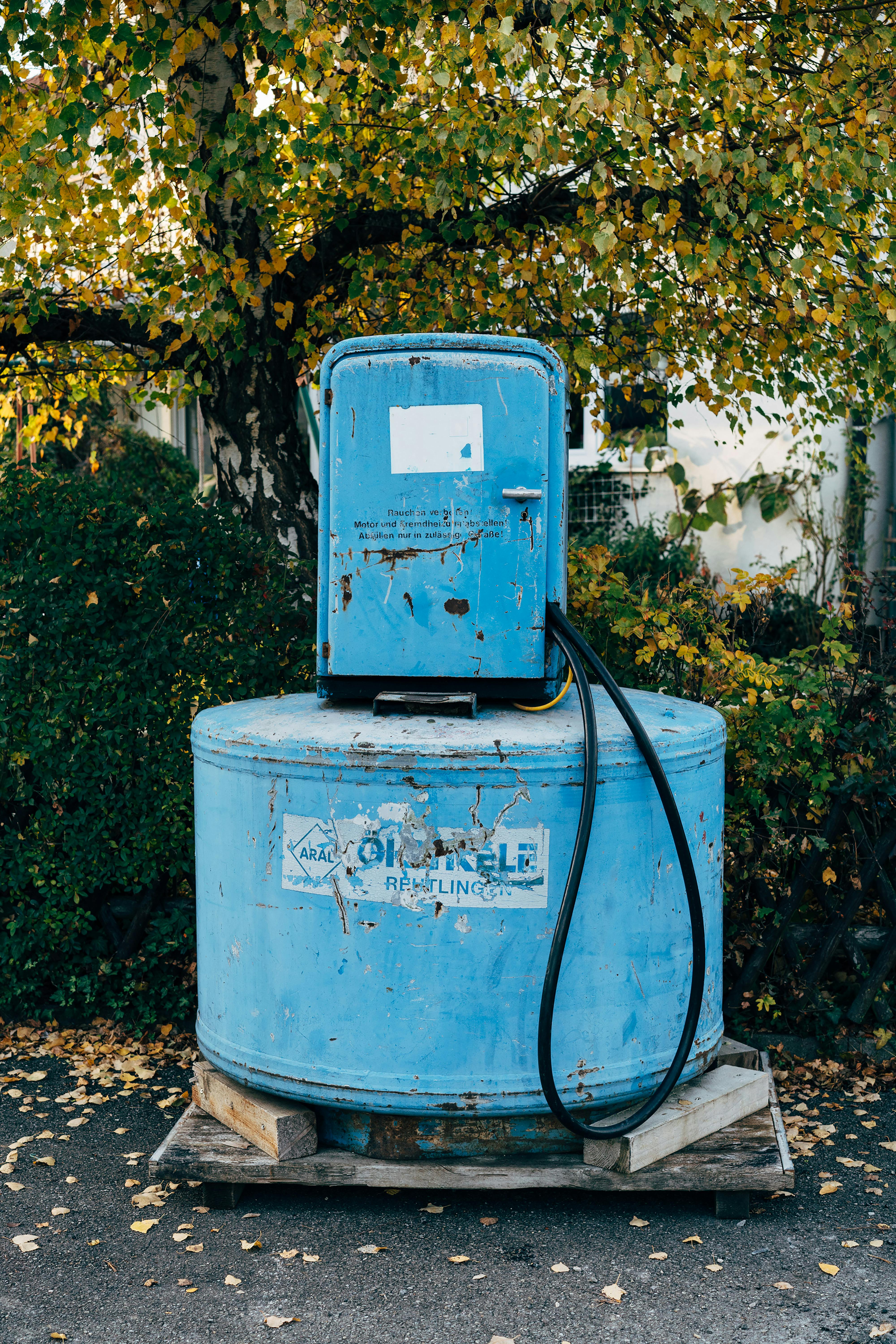 A blue gas pump sitting on a pallet · Free Stock Photo