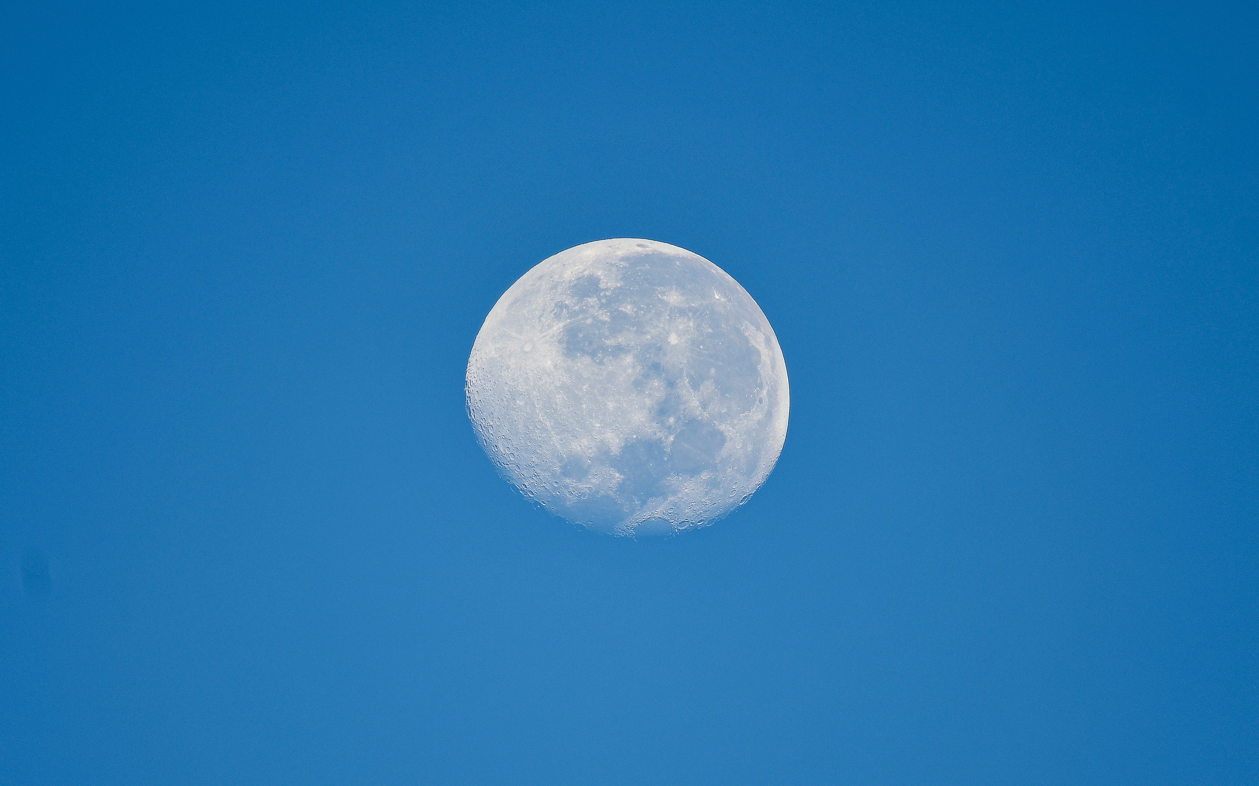 A full moon is seen in a clear blue sky · Free Stock Photo