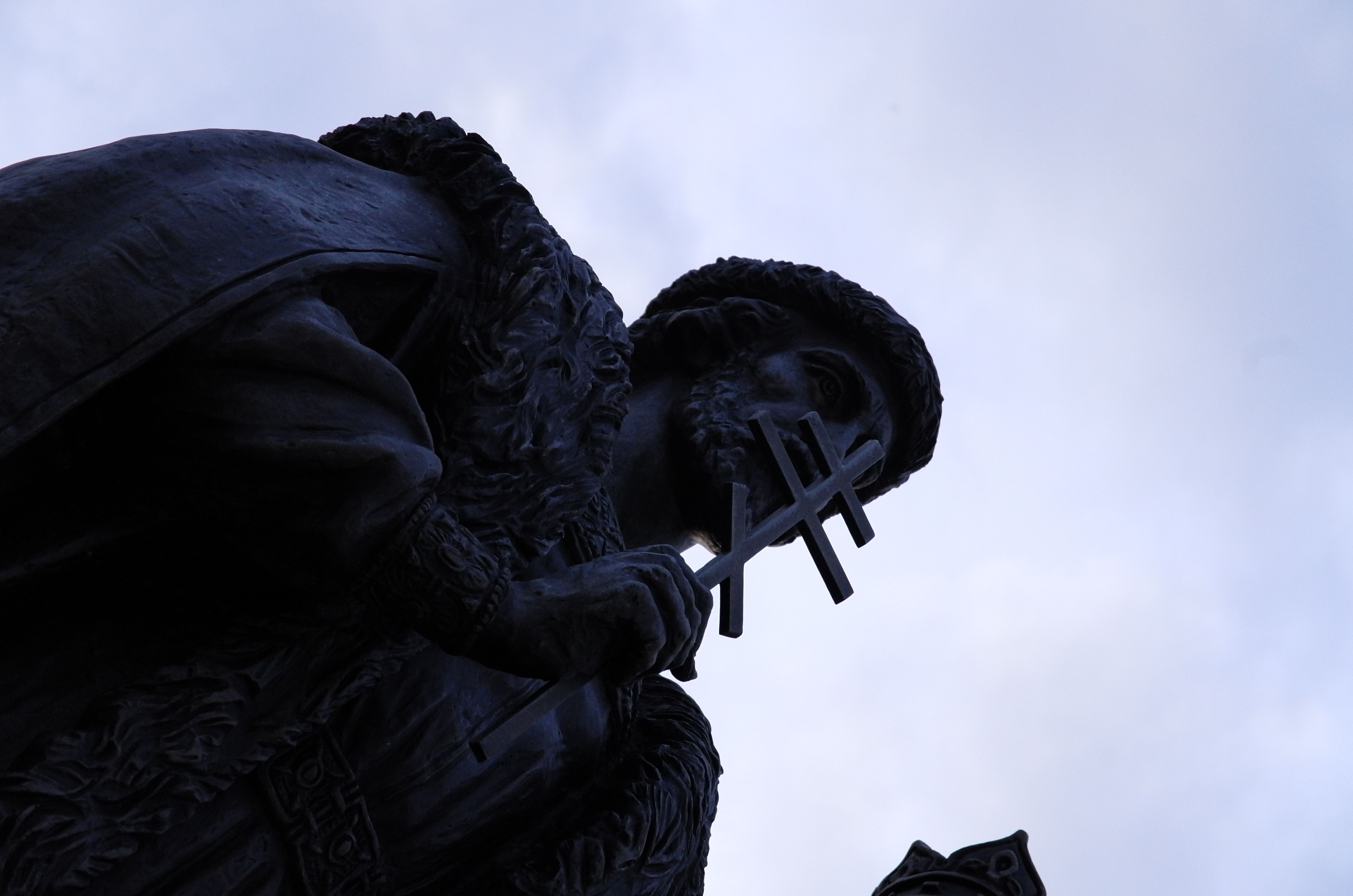 A statue of a man holding a pipe and a sword · Free Stock Photo