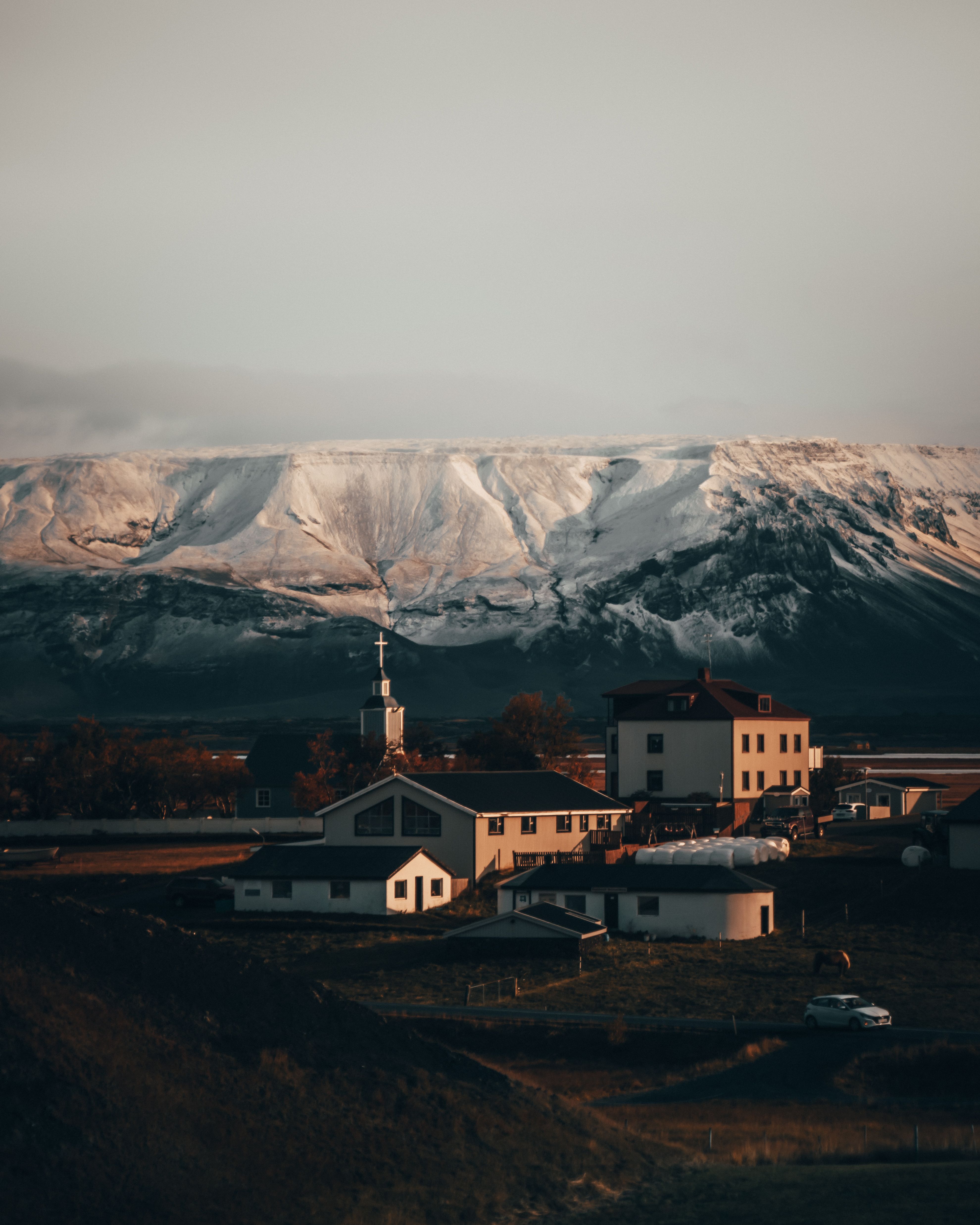 Village Buildings with Snow on Hill behind · Free Stock Photo